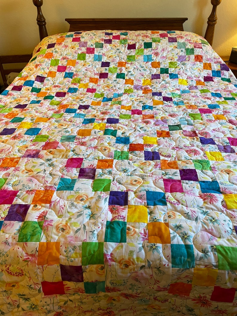 Multiple Batik Solid Blocks Are Arranged in an Irish Chain Pattern on a ...