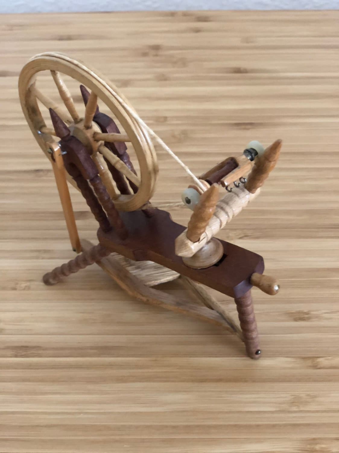 Miniature hand carved wooden spinning wheel with working wheel and pedal