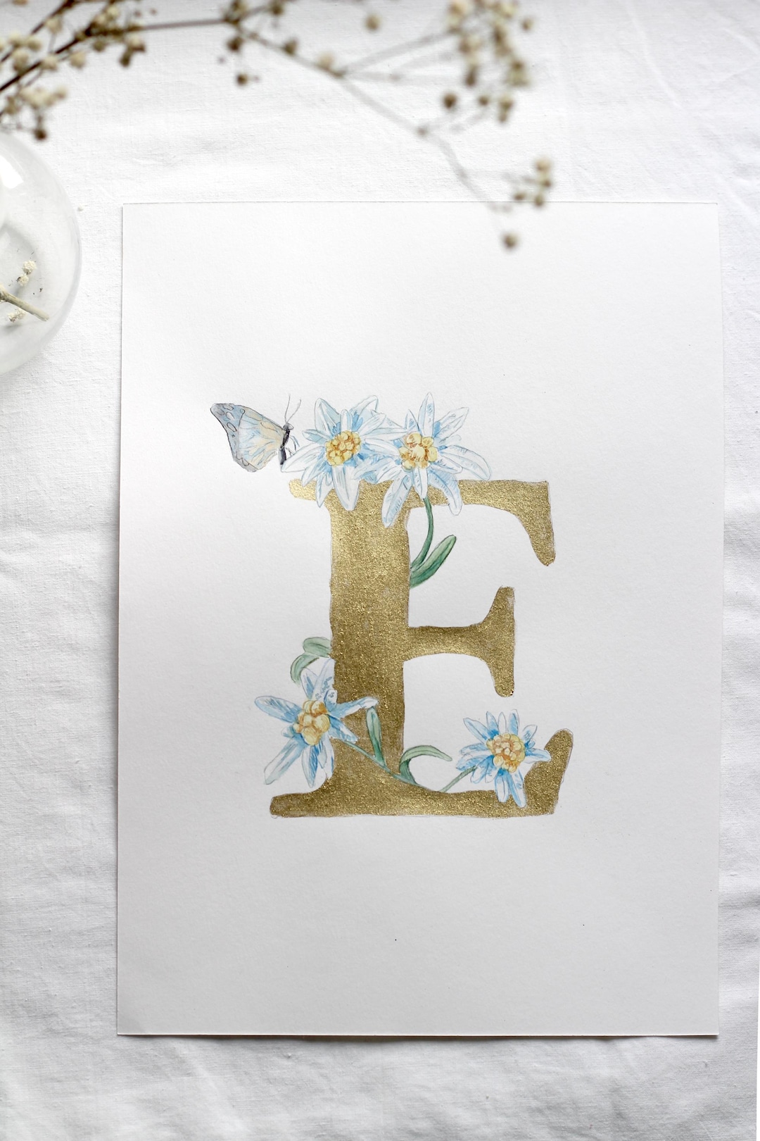Gold-colored Letter E Entwined With Edelweiss Flowers and a Blue ...