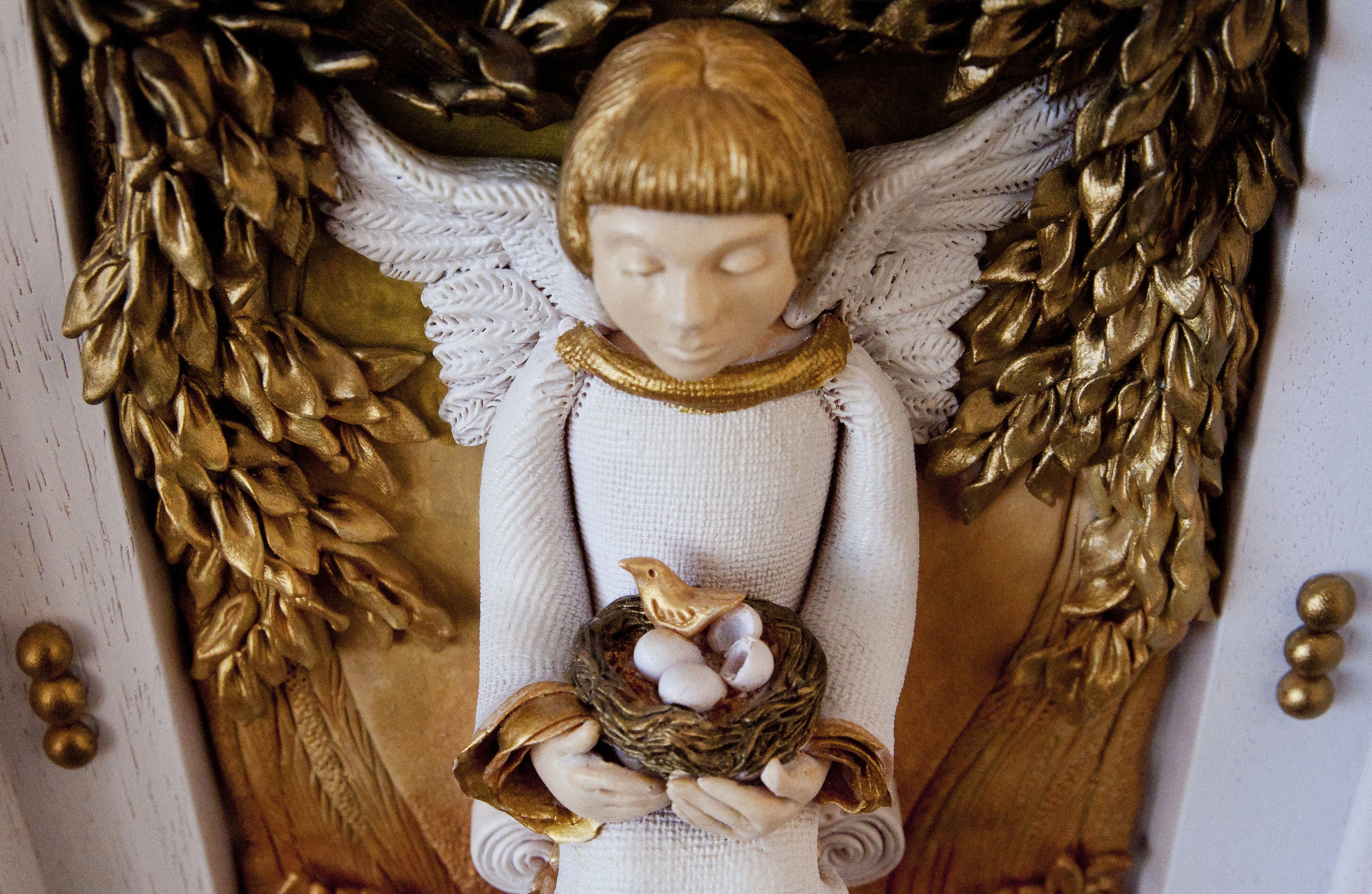 Sitting Angel con un nido de pájaro: relieve con un marco de madera ...