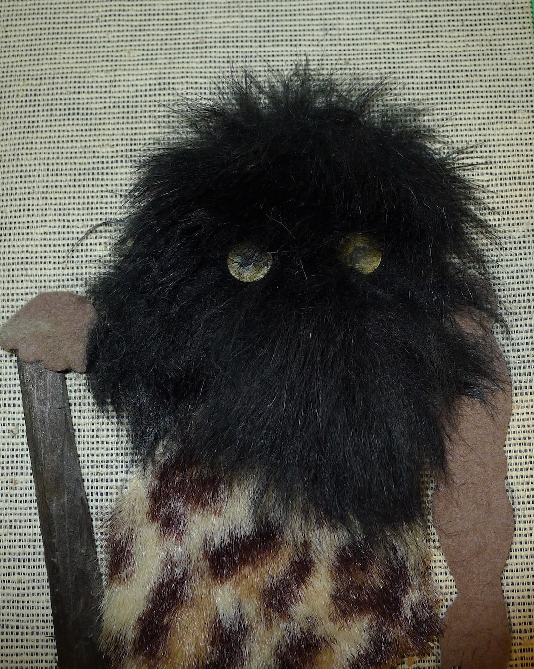 Friendly ancient wall hanging hairy caveman dressed in furs from the 60 ...