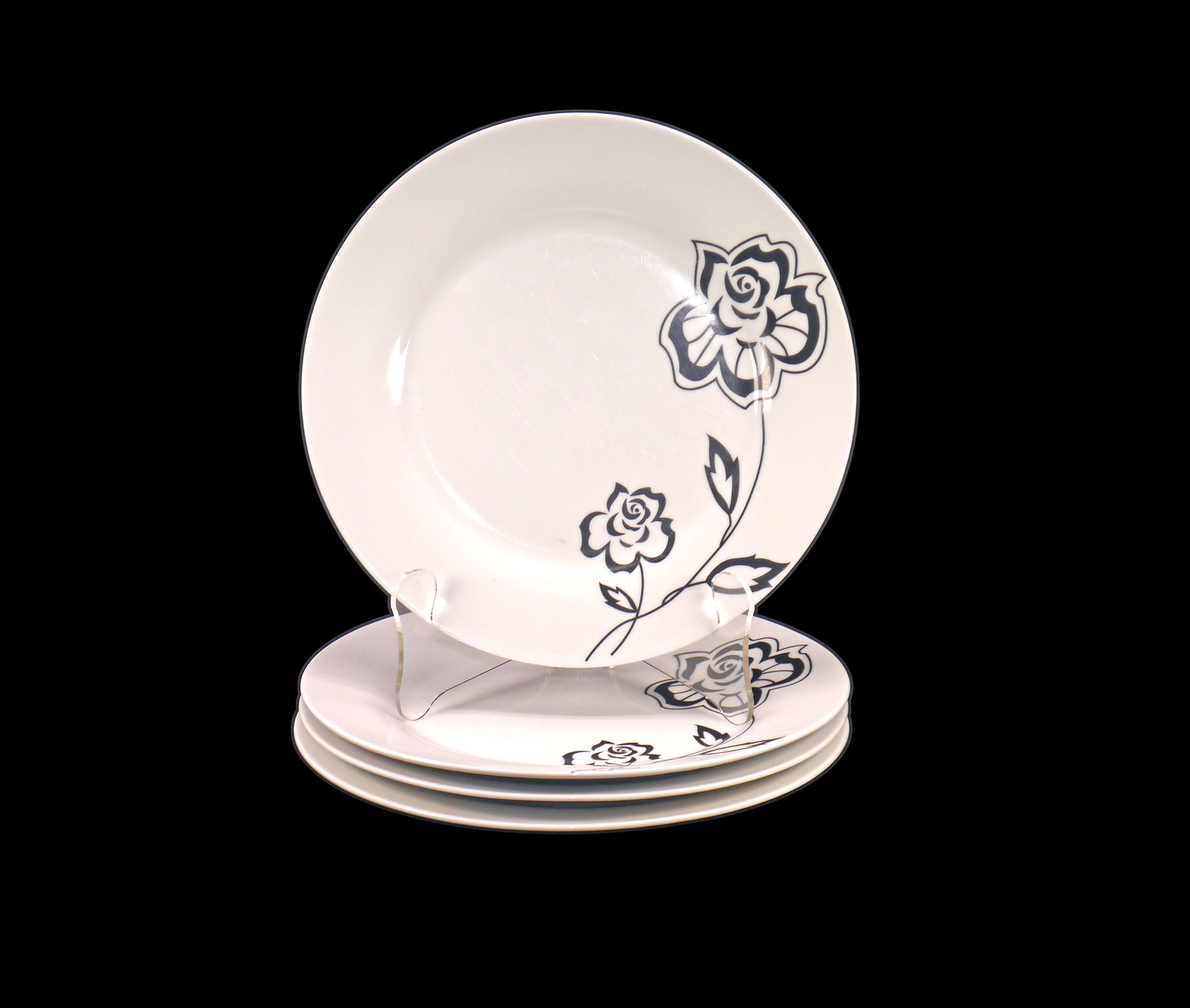 Four Moda large dinner plates made by Oneida. Black flowers on white.
