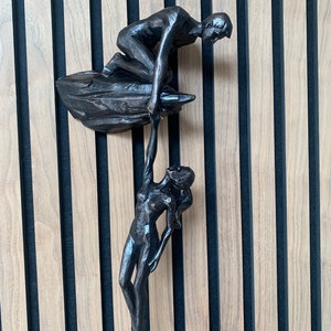 Man on Cliff Edge Holding a Hanging Woman Sculpture Wall Hanging Statue ...