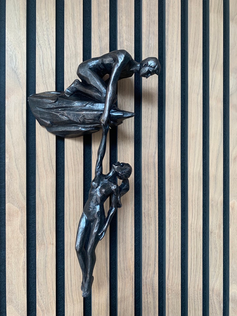 Man on Cliff Edge Holding a Hanging Woman Sculpture Wall Hanging Statue ...