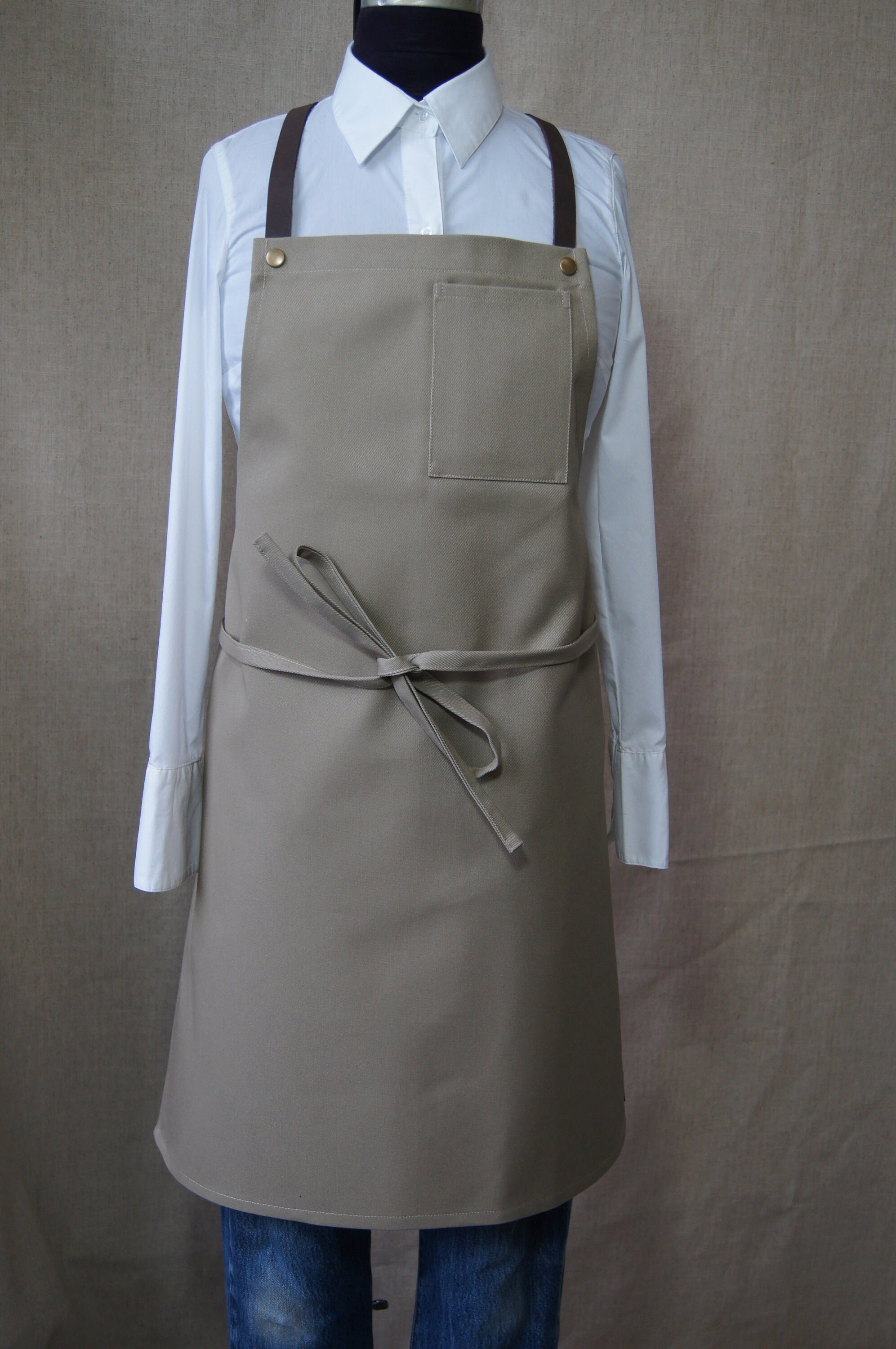 Apron with crossed leather straps at the back