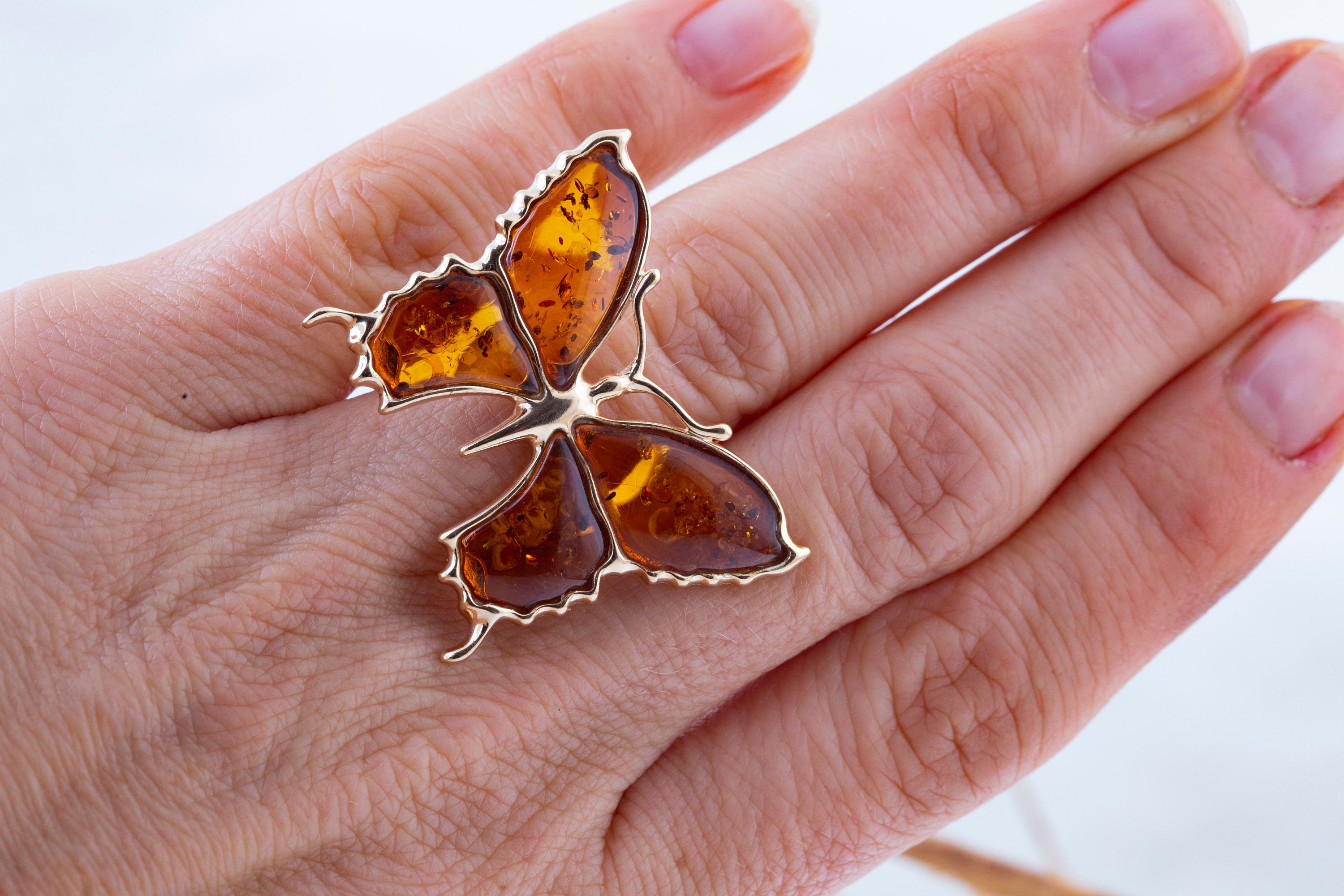 Amber & Gold. Four pieces of cognac Baltic amber. Butterfly shaped ...