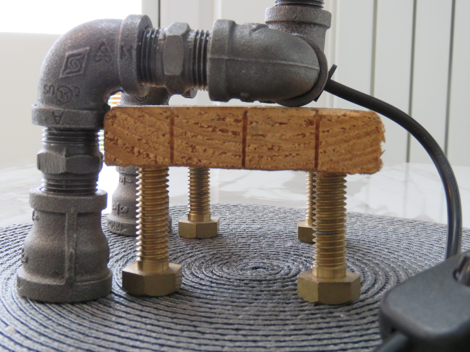 Pipelight Figure Sat on a Simple Wooden Bench Made From Industrial Pipe ...