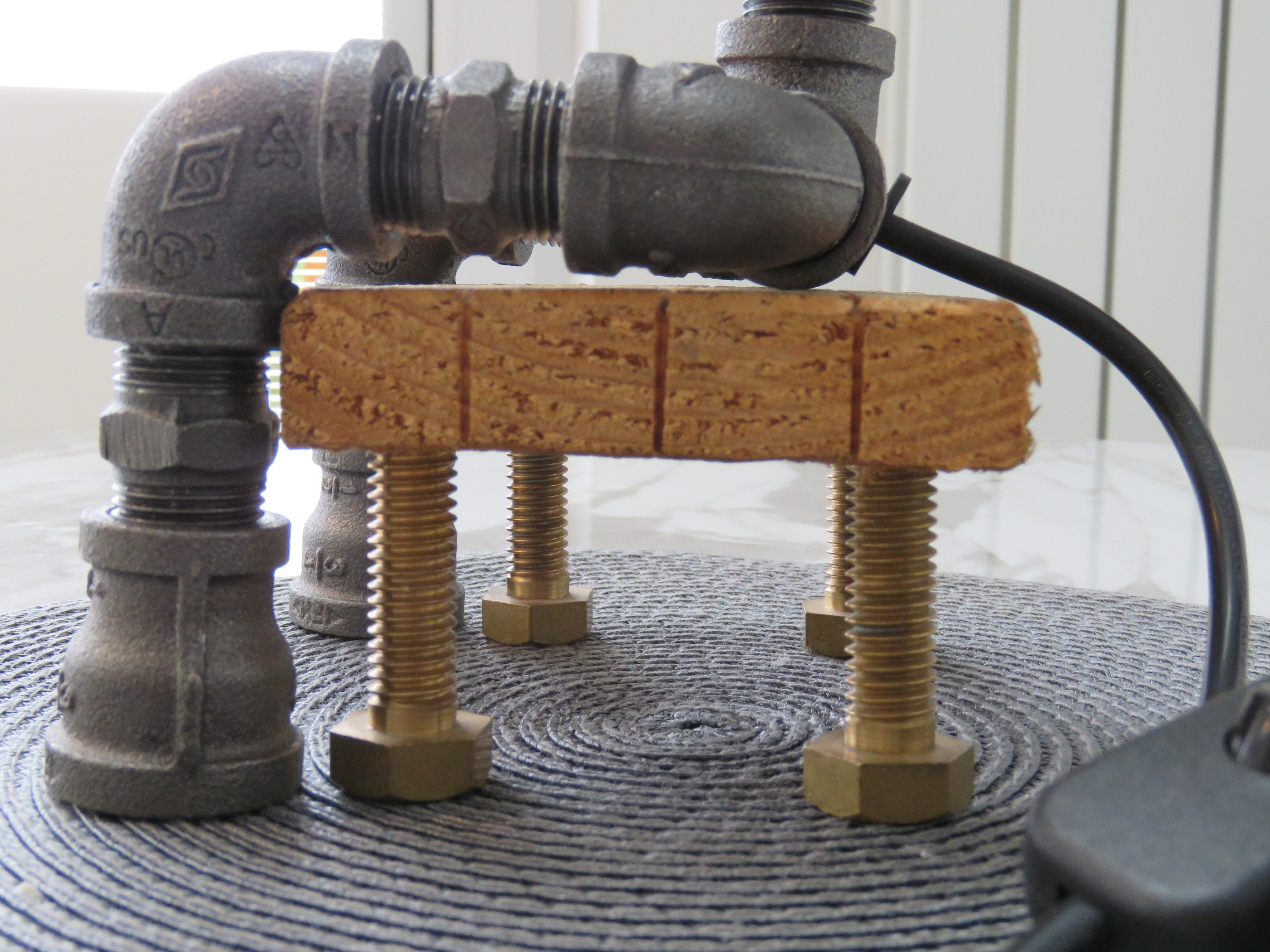 Pipelight Figure Sat on a Simple Wooden Bench Made From Industrial Pipe ...