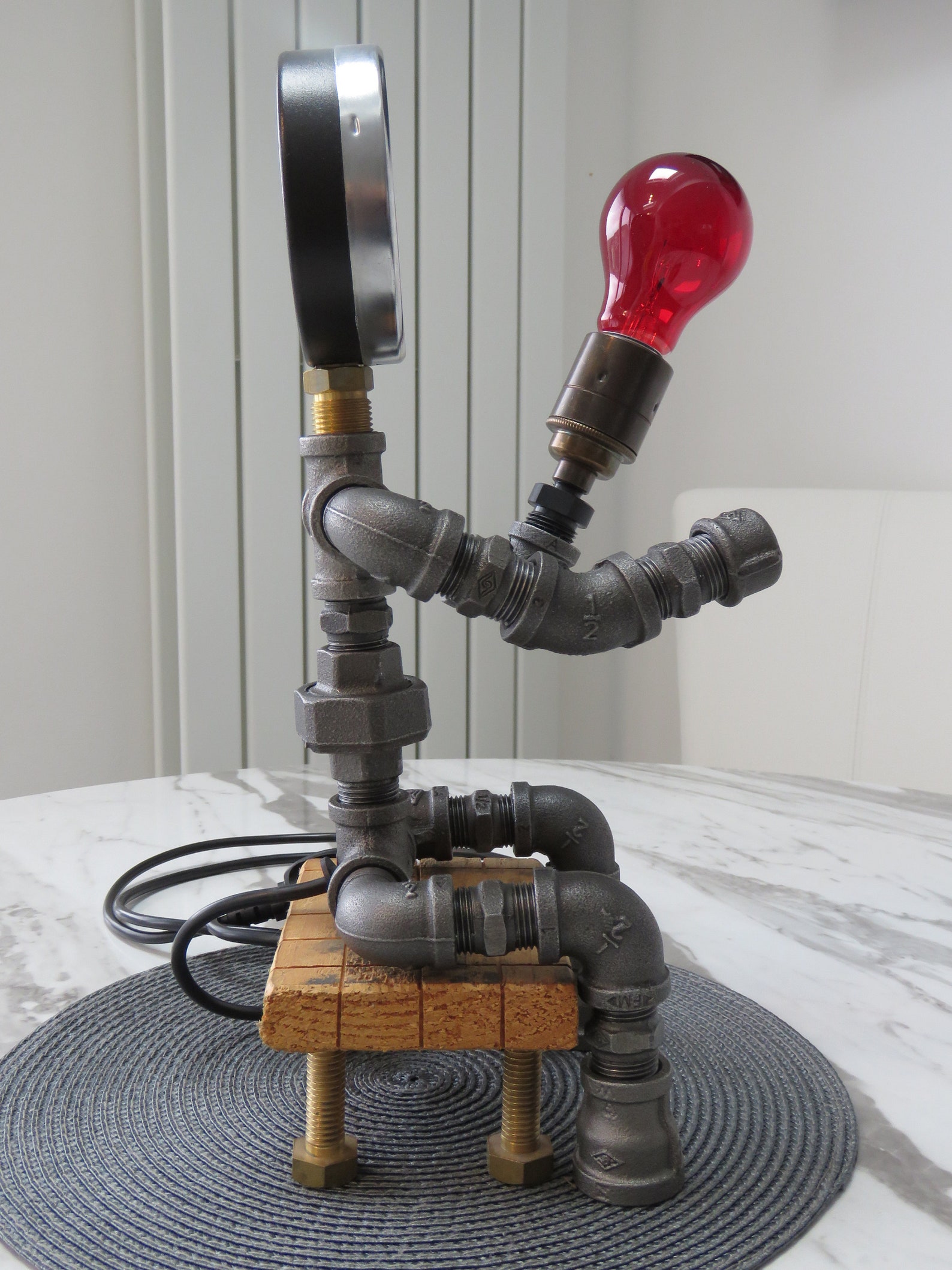 Pipelight Figure Sat on a Simple Wooden Bench Made From Industrial Pipe ...