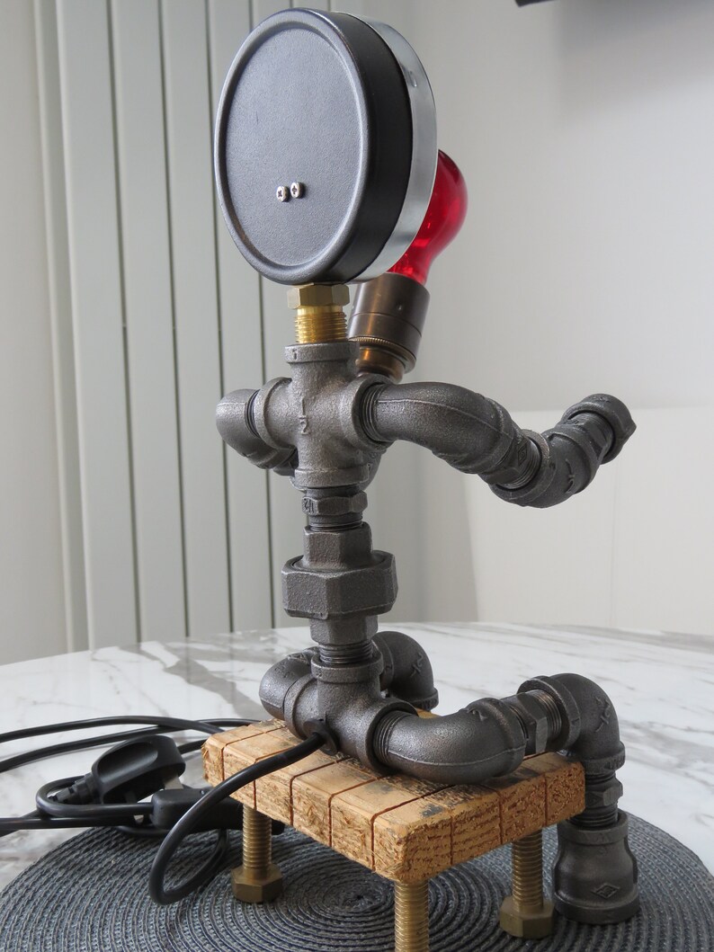 Pipelight Figure Sat on a Simple Wooden Bench Made From Industrial Pipe ...