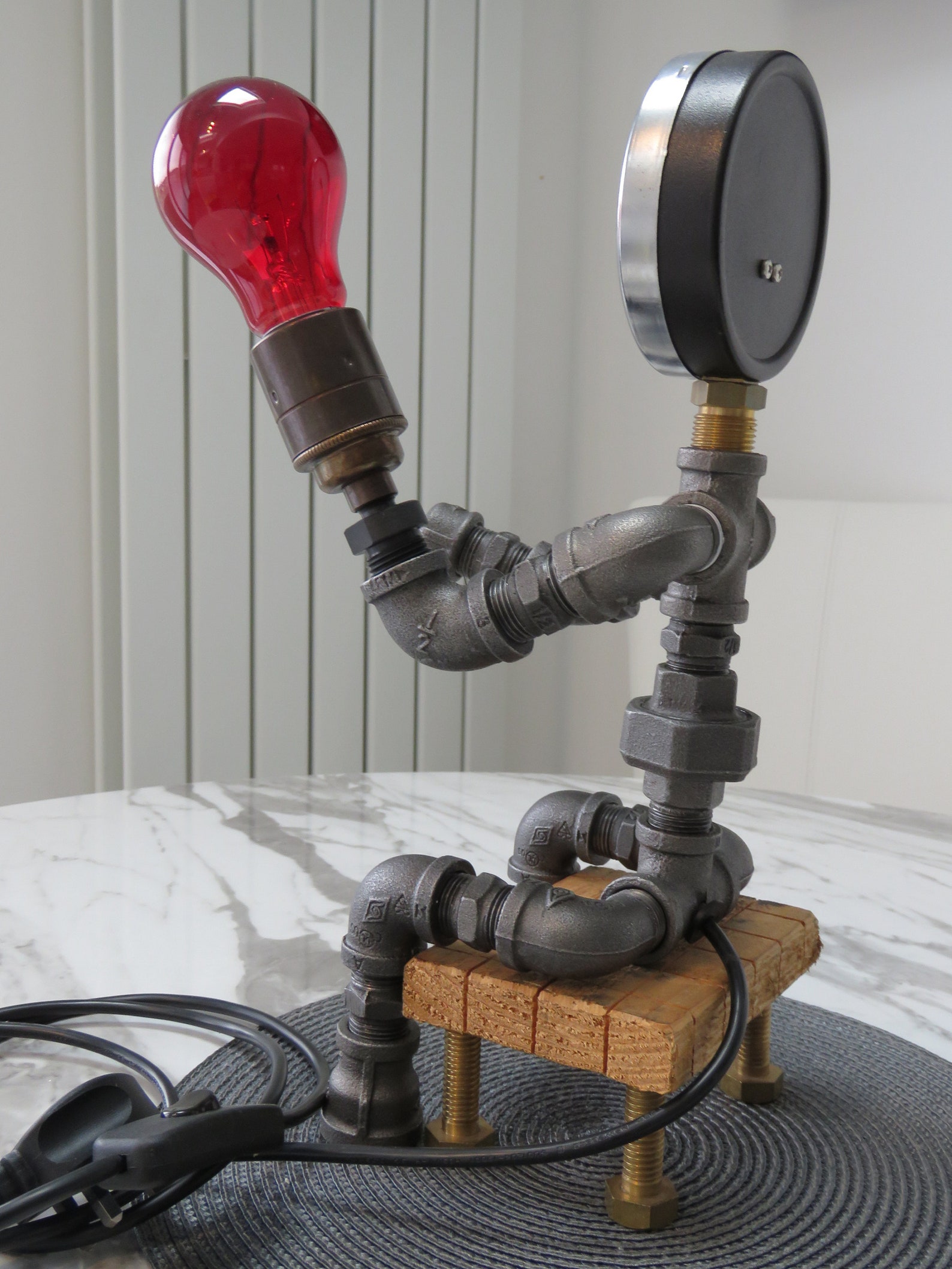 Pipelight Figure Sat on a Simple Wooden Bench Made From Industrial Pipe ...