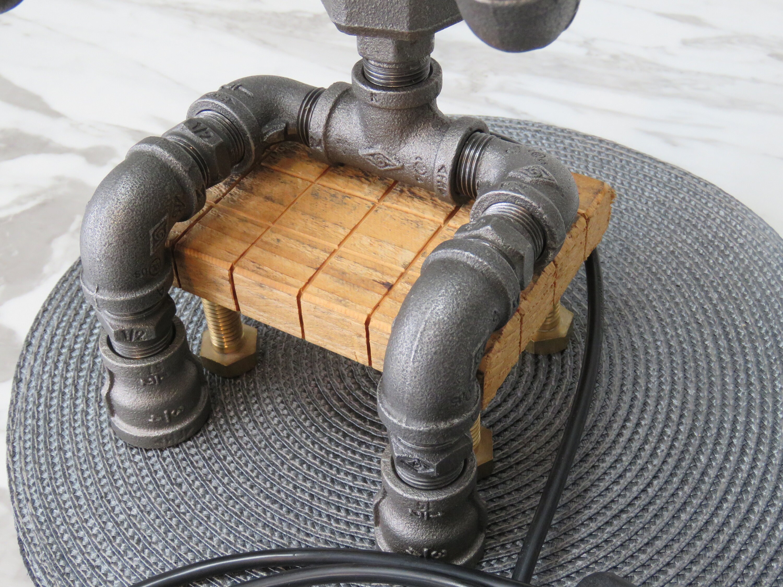 Pipelight Figure Sat on a Simple Wooden Bench Made From Industrial Pipe ...