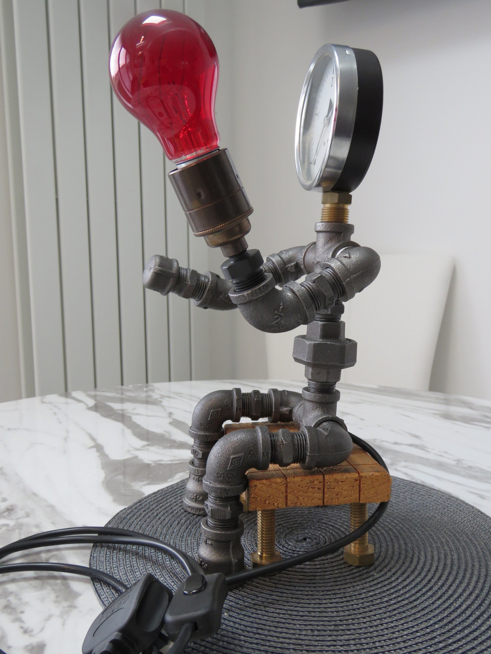 Pipelight Figure Sat on a Simple Wooden Bench Made From Industrial Pipe ...
