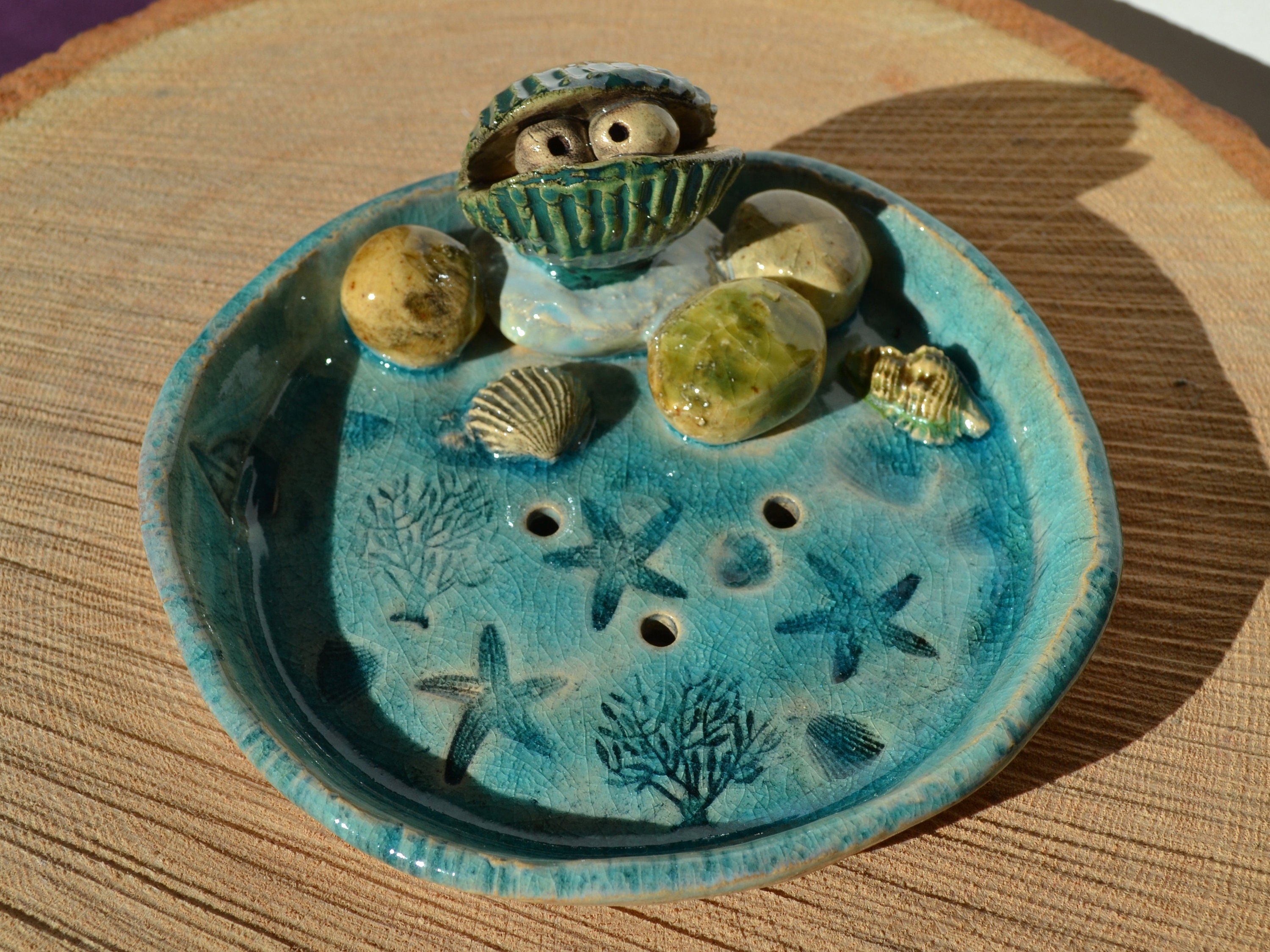 Round ceramic soap dish shell on stones