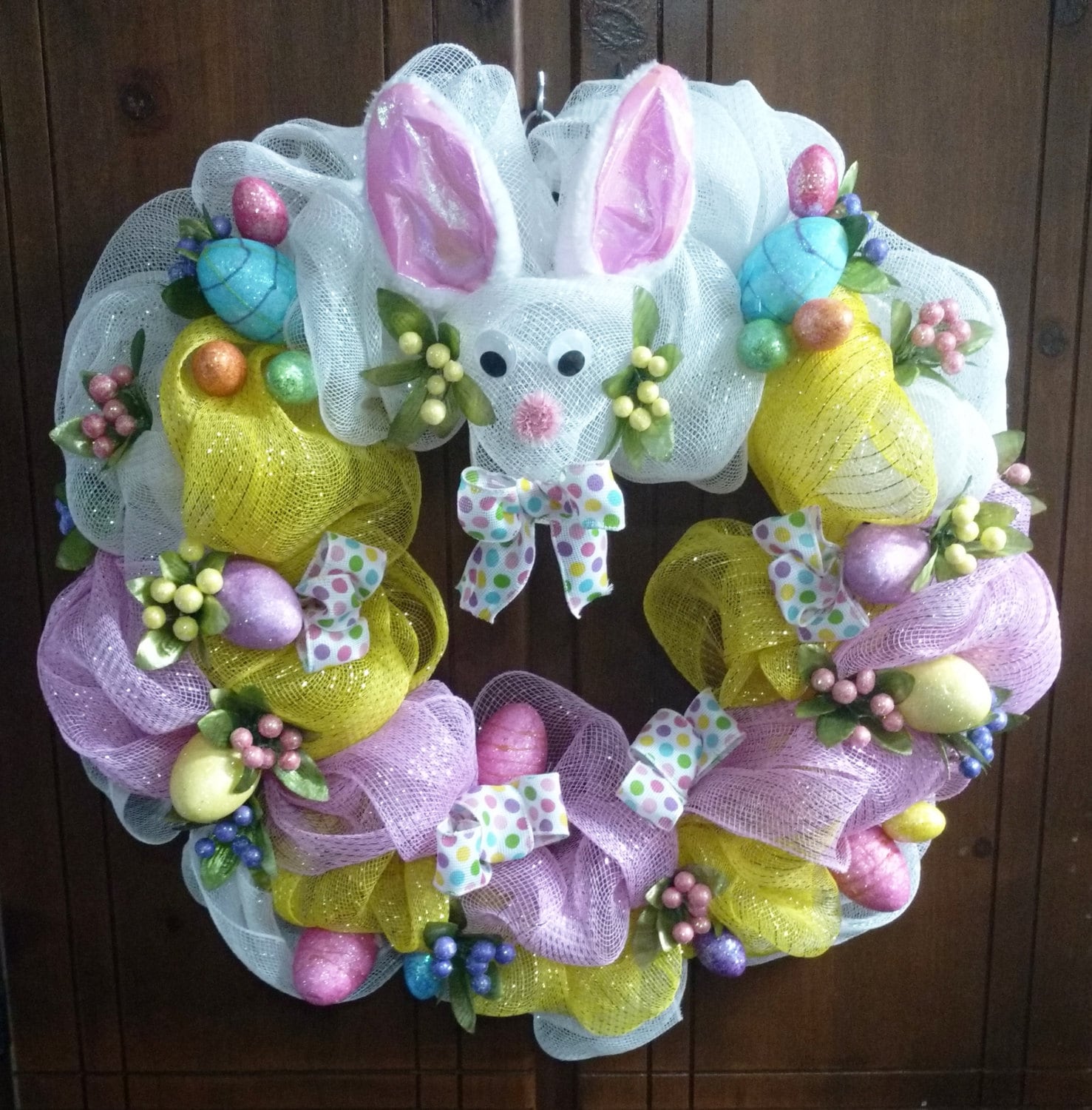 Corona de Pascua con una cara de conejo rodeada de huevos de Pascua ...