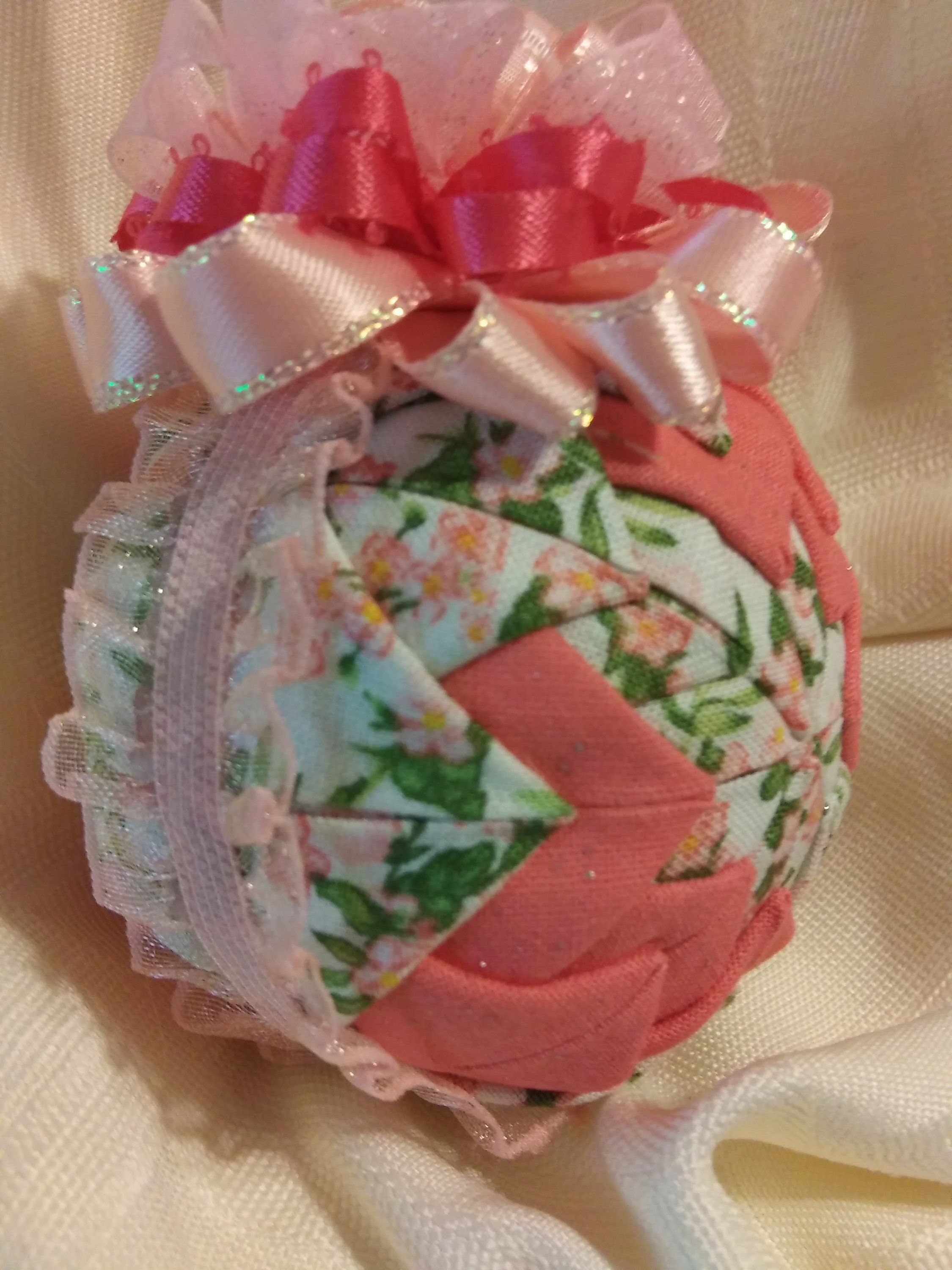 Pink sparkle and floral fabrics folded star ball ornament with a ...