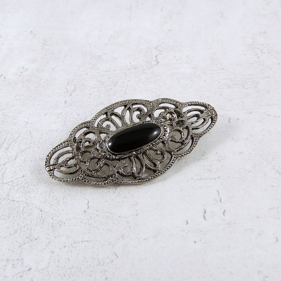 A Classic Vintage Oval Brooch With a Black Centre on a Decorative ...