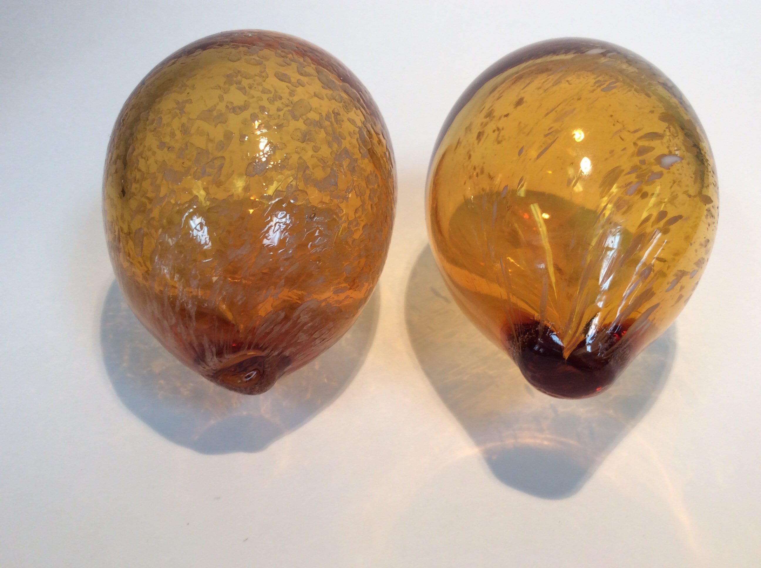 Pair Blenko Glass hand blown egg paperweights amber with white speckles.