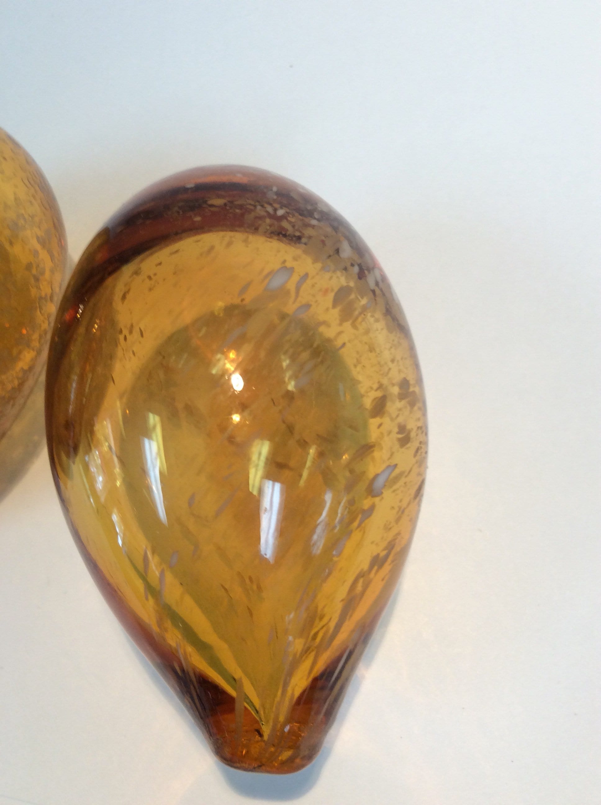 Pair Blenko Glass hand blown egg paperweights amber with white speckles.