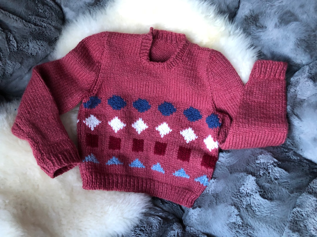 Un pull rose tricoté à la main vintage avec des formes géométriques ...