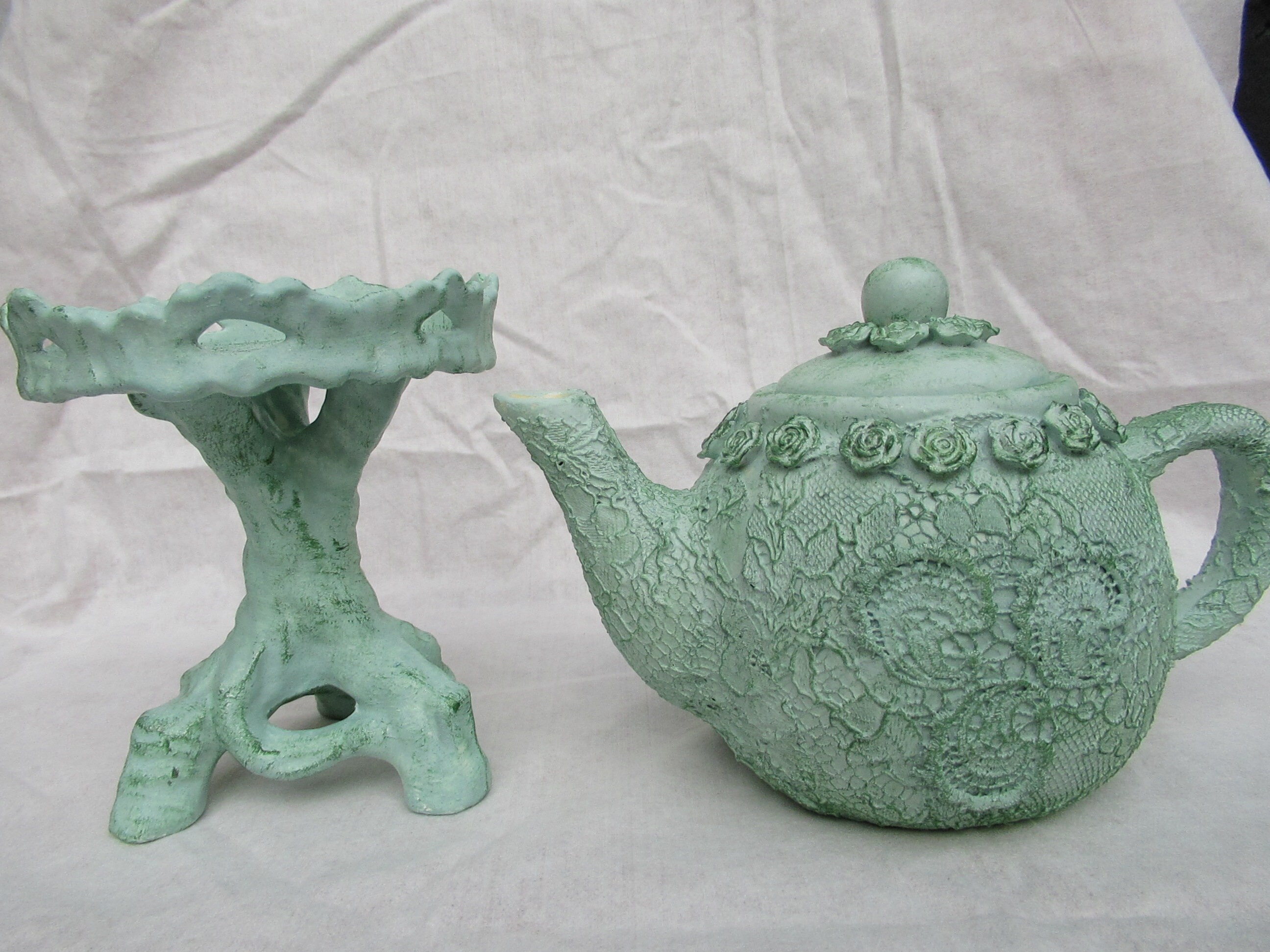 Green Teapot Covered in Lace, on a Stand With Resin Flowers Round the ...