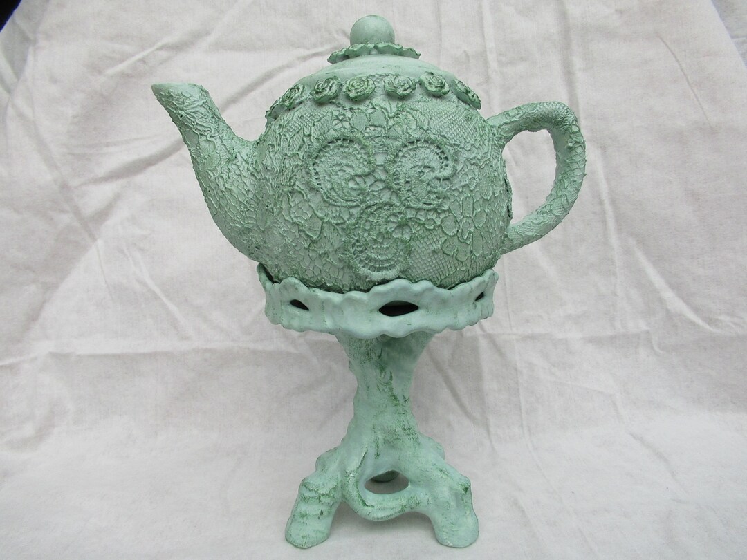 Green Teapot Covered in Lace, on a Stand With Resin Flowers Round the ...