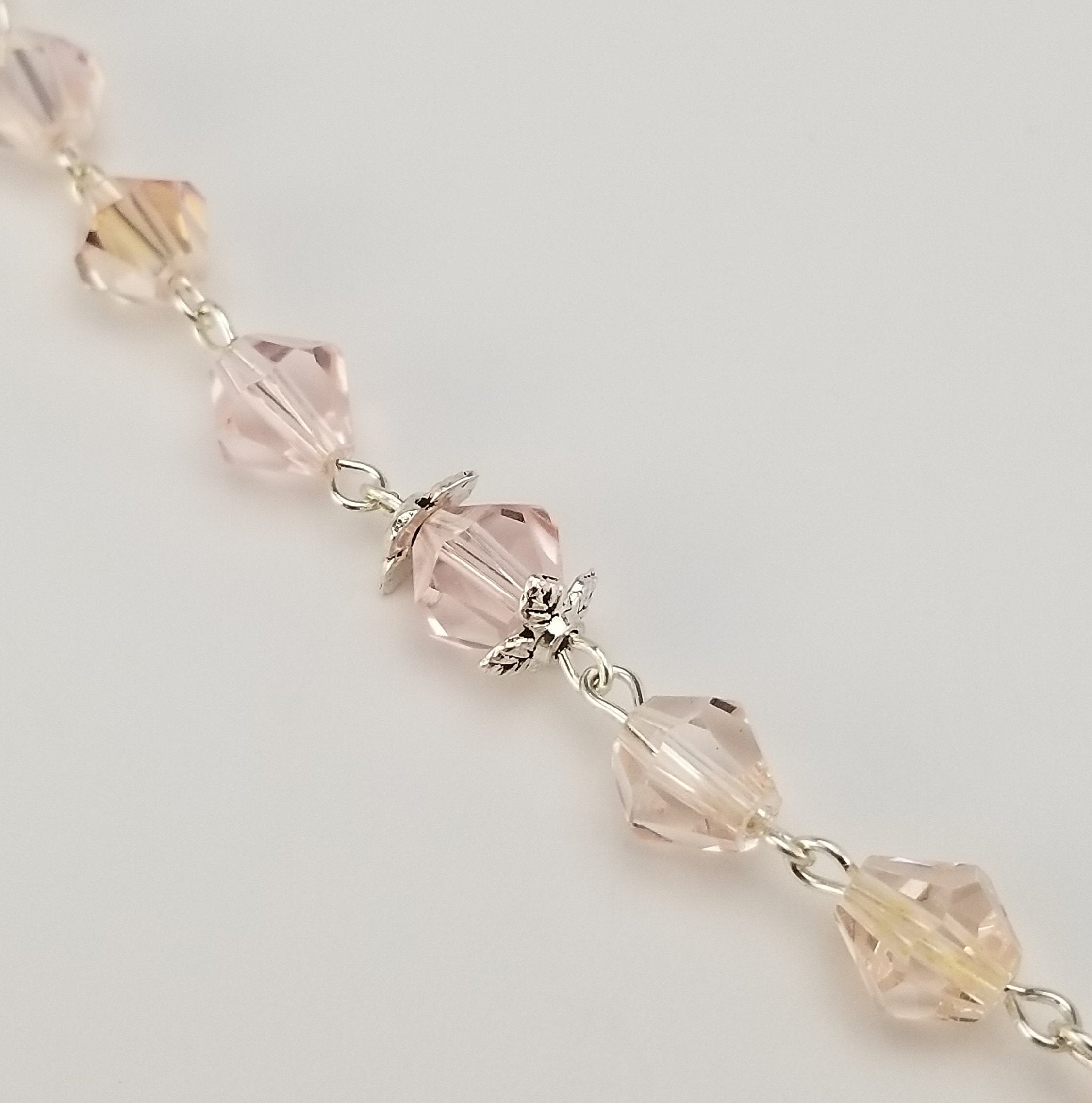 Rosario. Rosario de cuentas facetadas de color rosa claro con ...