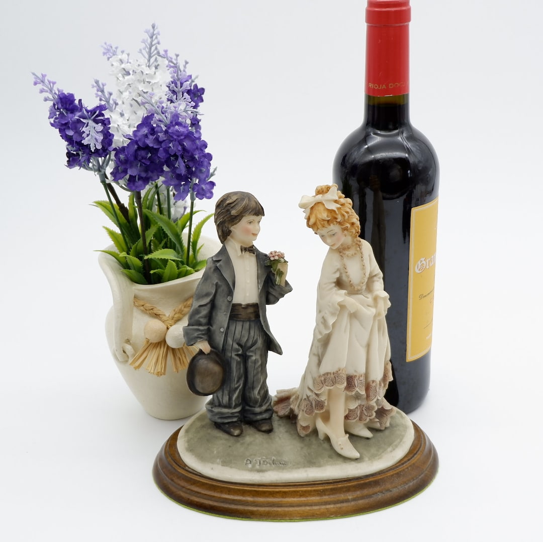 A Belcari Figurine of Boy and Girl Playing Dress up - Oval Wood Base ...
