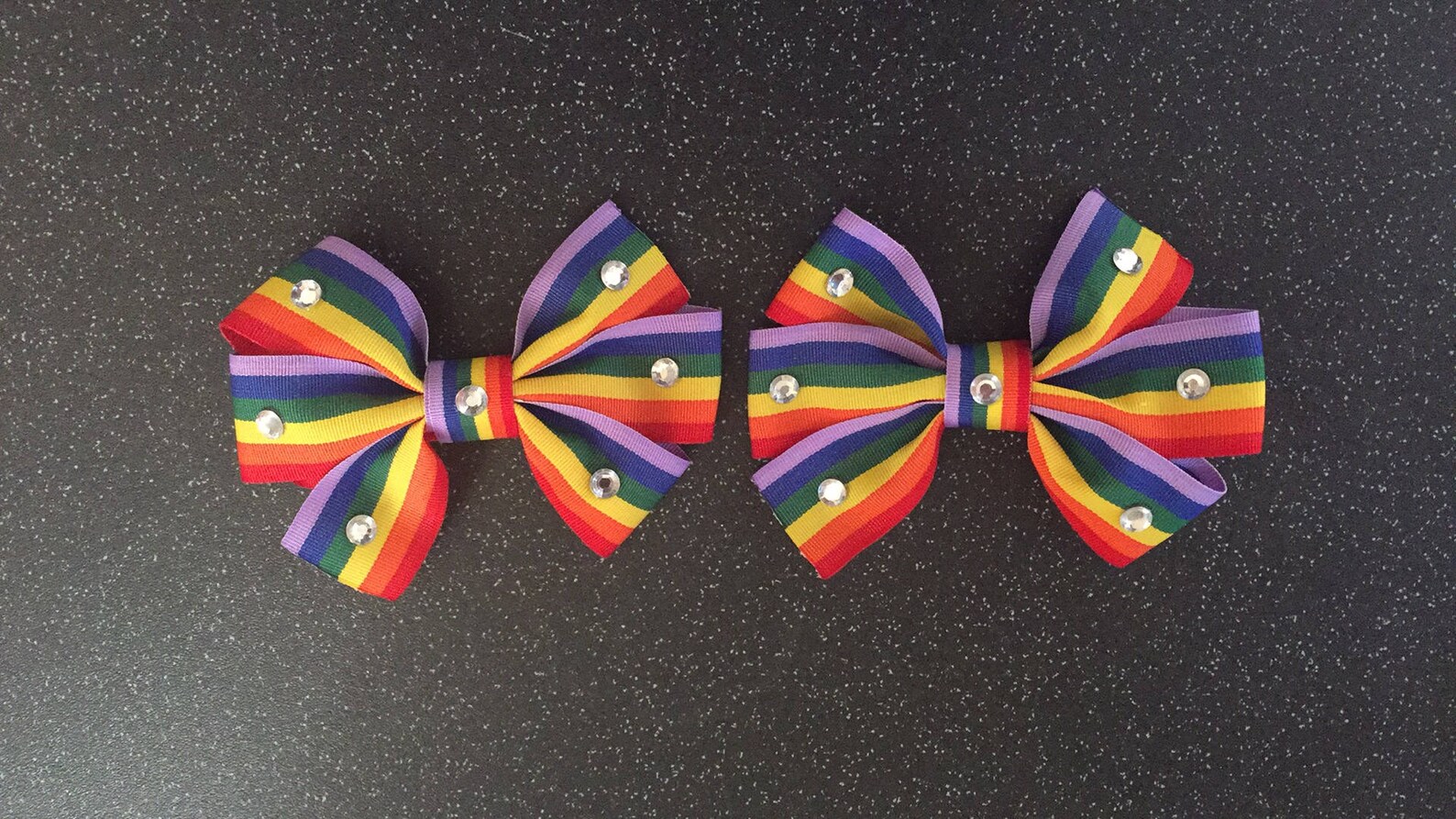 A pair of rainbow bows | Etsy