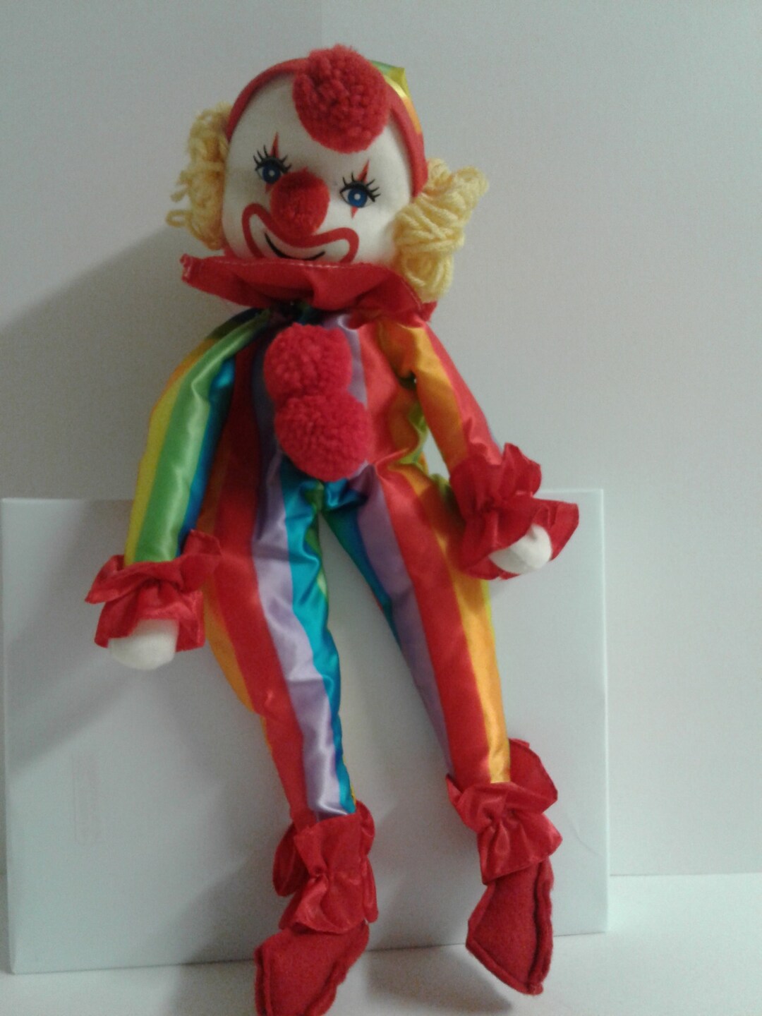 Payaso arcoíris musical Dolmax, muñeco de cuerda, se sienta en el ...