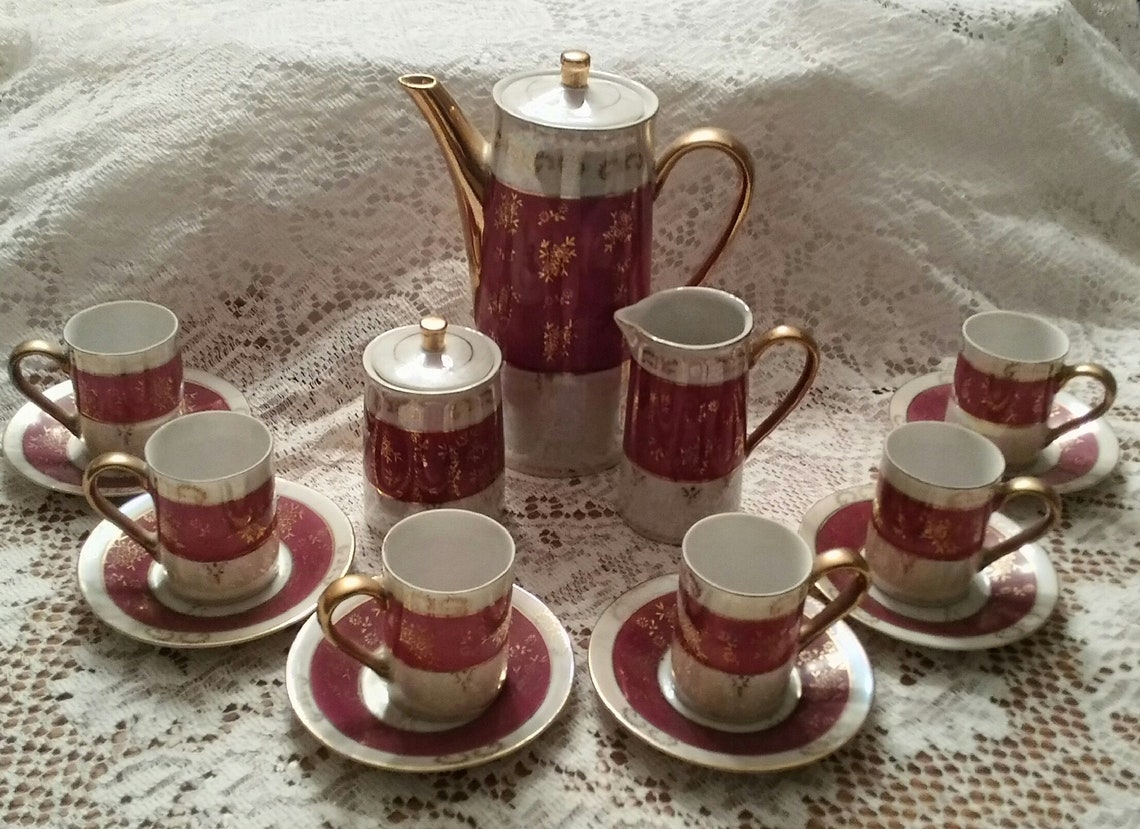 A 15 Piece Porcelain Tea Set in White, Maroon, and Gold Lusterware. the ...