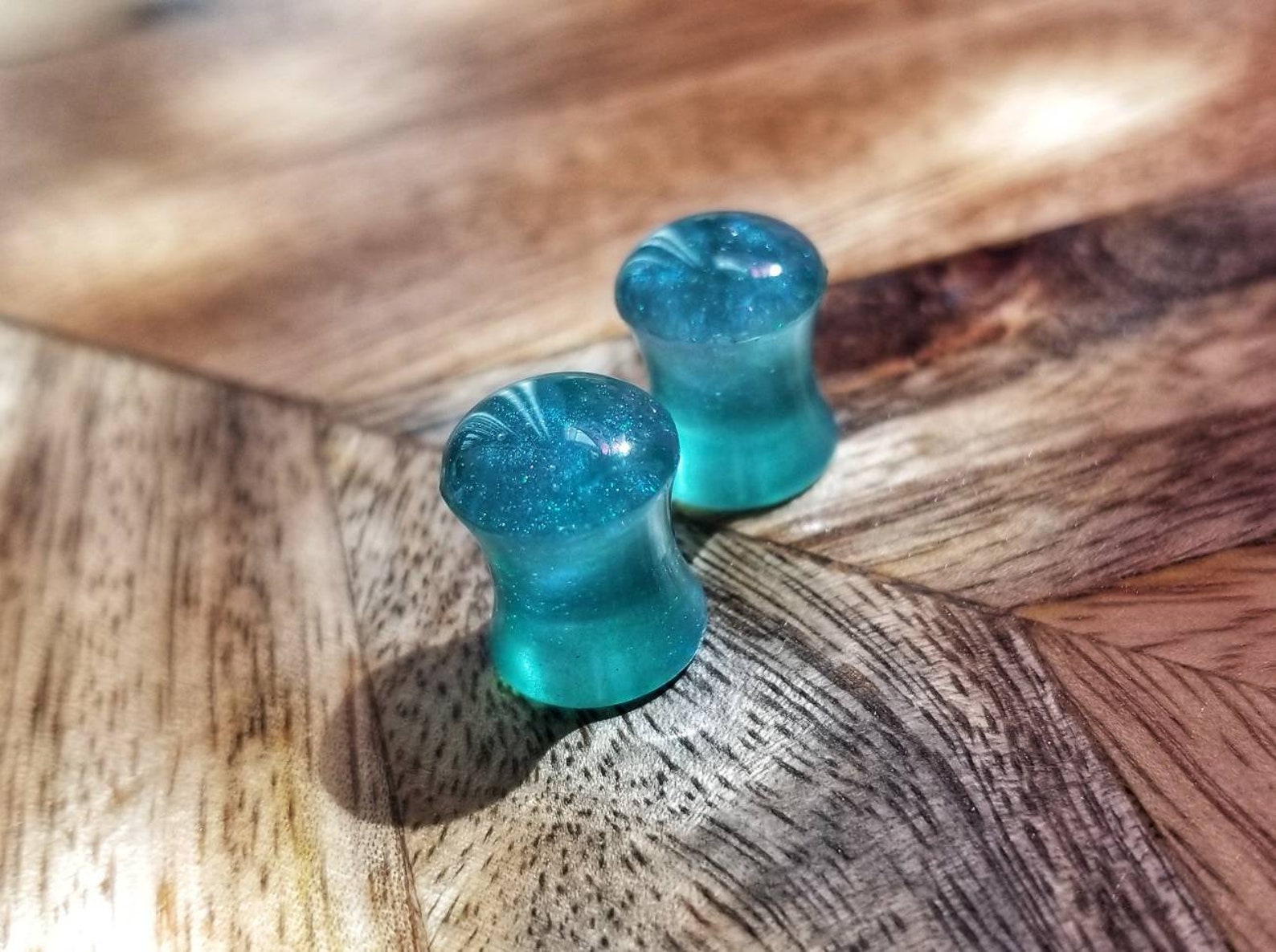 Teal colored double flared plugs made with resin and mica | Etsy