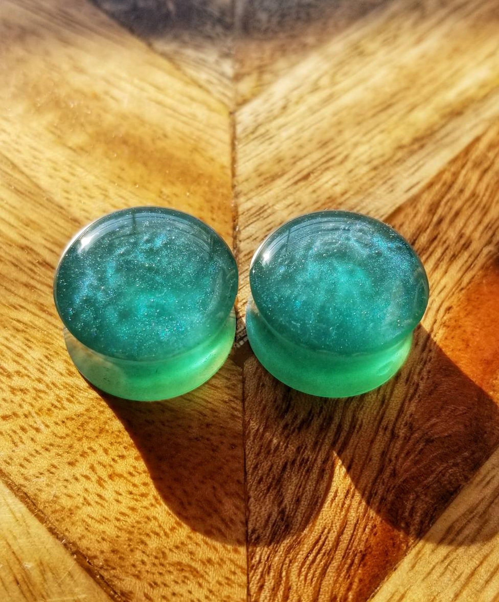Teal colored double flared plugs made with resin and mica | Etsy
