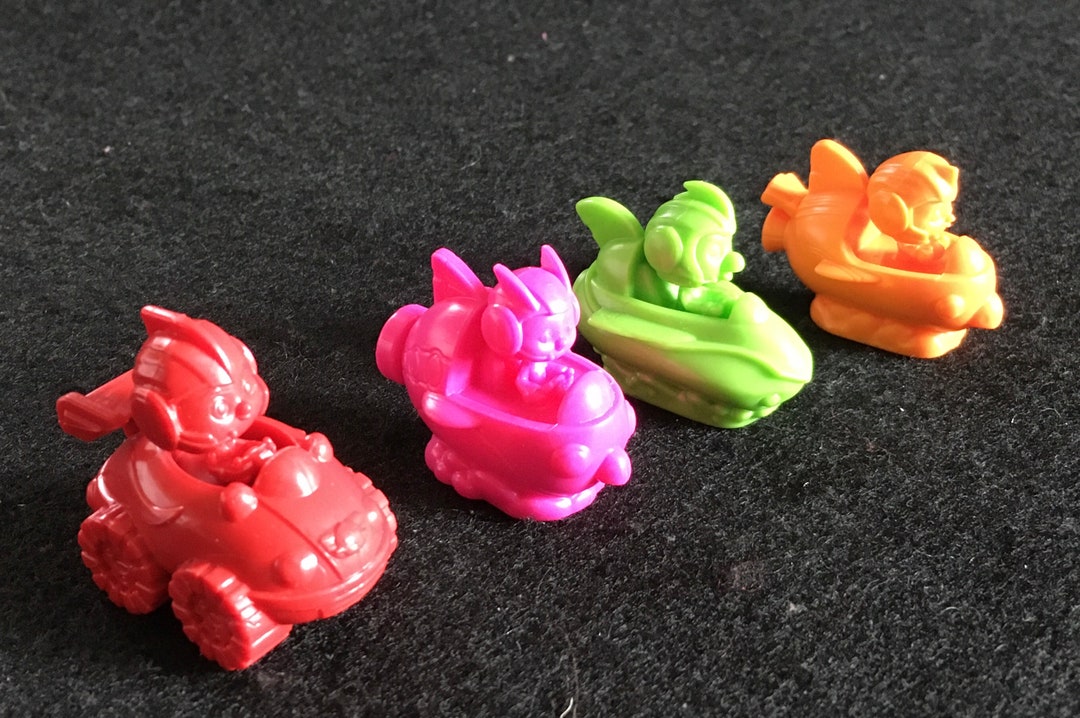 Four Brightly Colored Plastic Game Tokens Modeled After Kids in Space ...