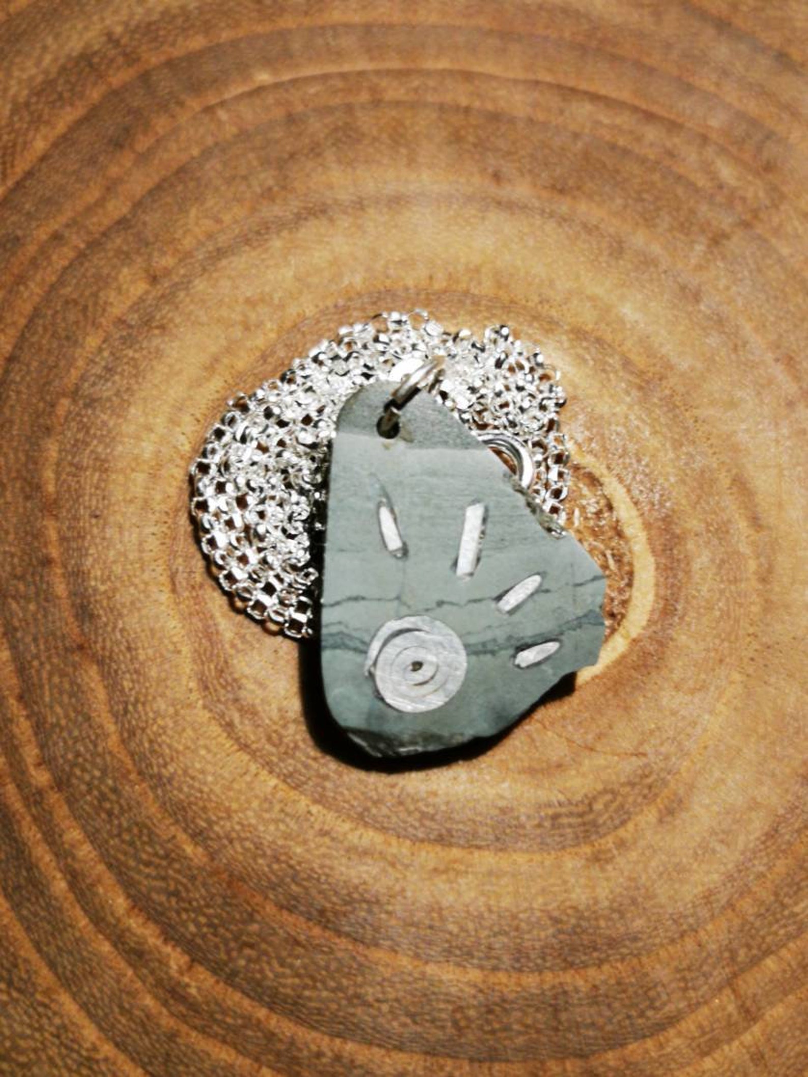 Gray Welsh slate pendant with a silver sunburst | Etsy