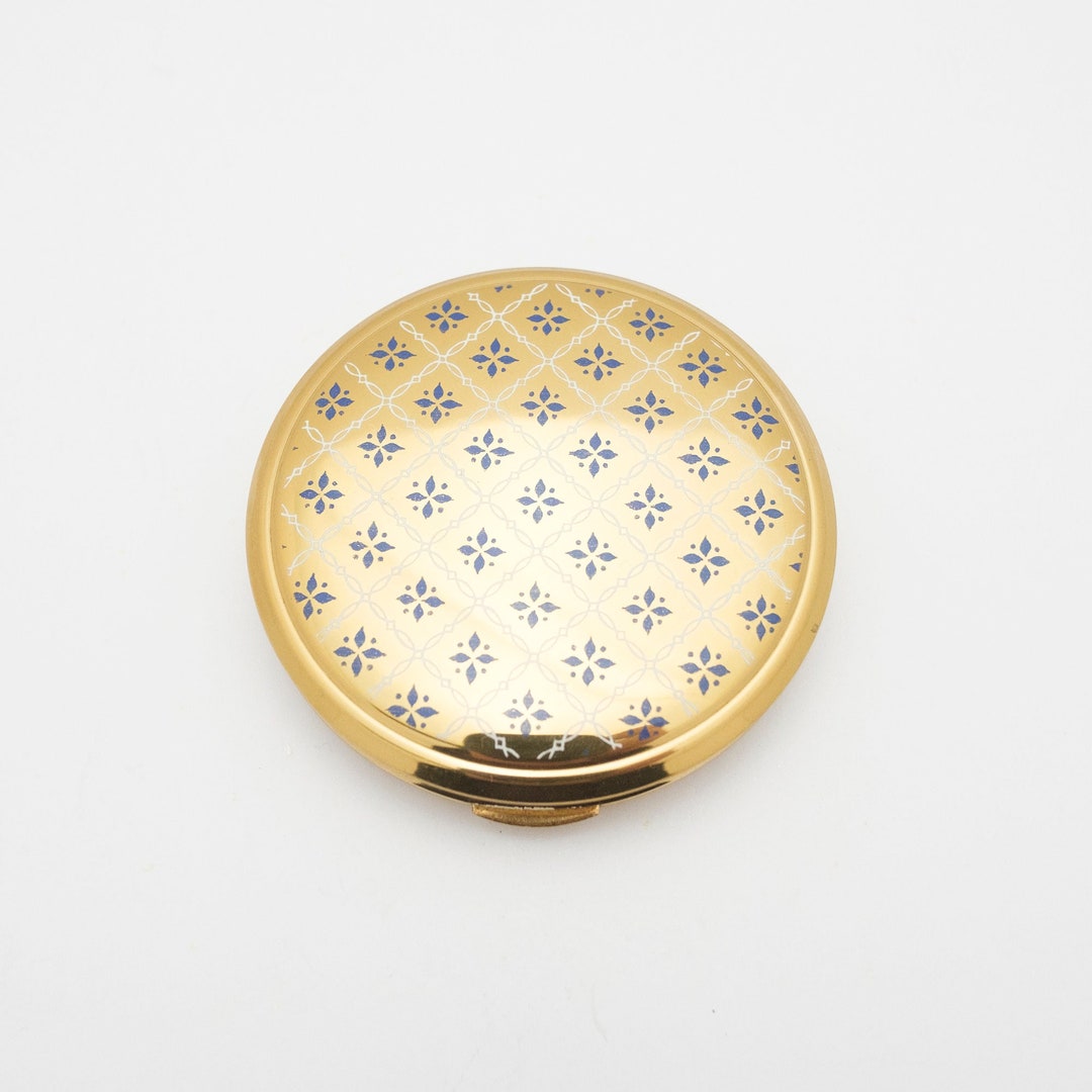 Brass Compact With Black and White Pattern Decor on a Brass Background ...