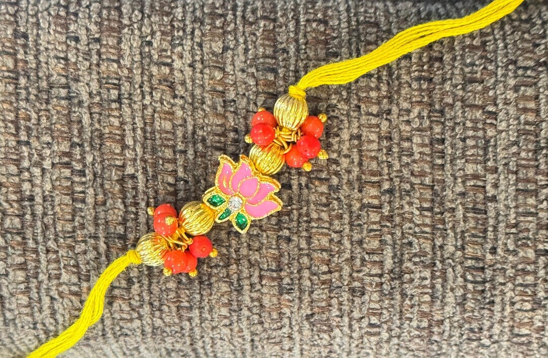 Beautiful Rakhis With Hanging Charm, Gold Beads, Pink and Red Lotus ...