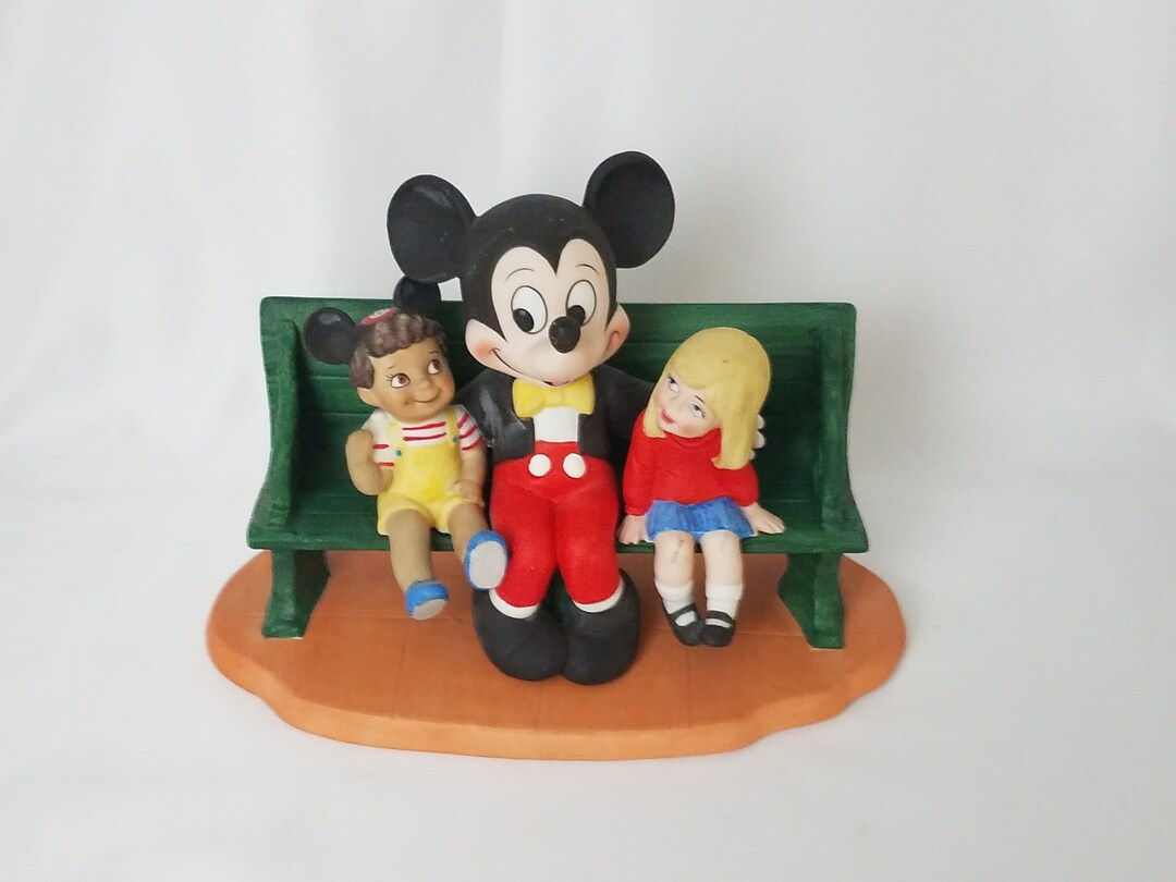Mickey Mouse Sits on a Bench Between Two Children as Part of This ...