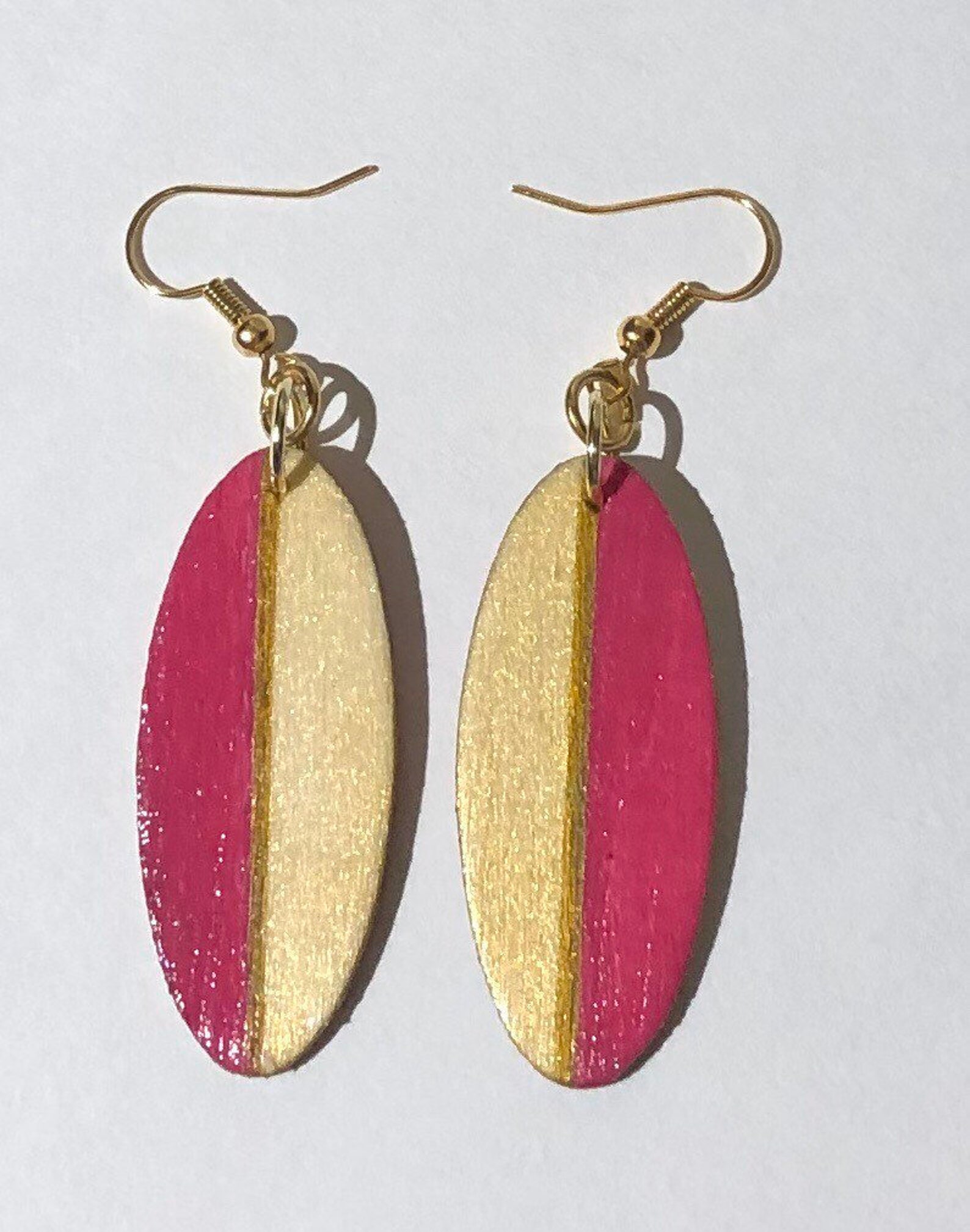 Pequeños pendientes de madera de forma oblonga pintados en hermosos ...