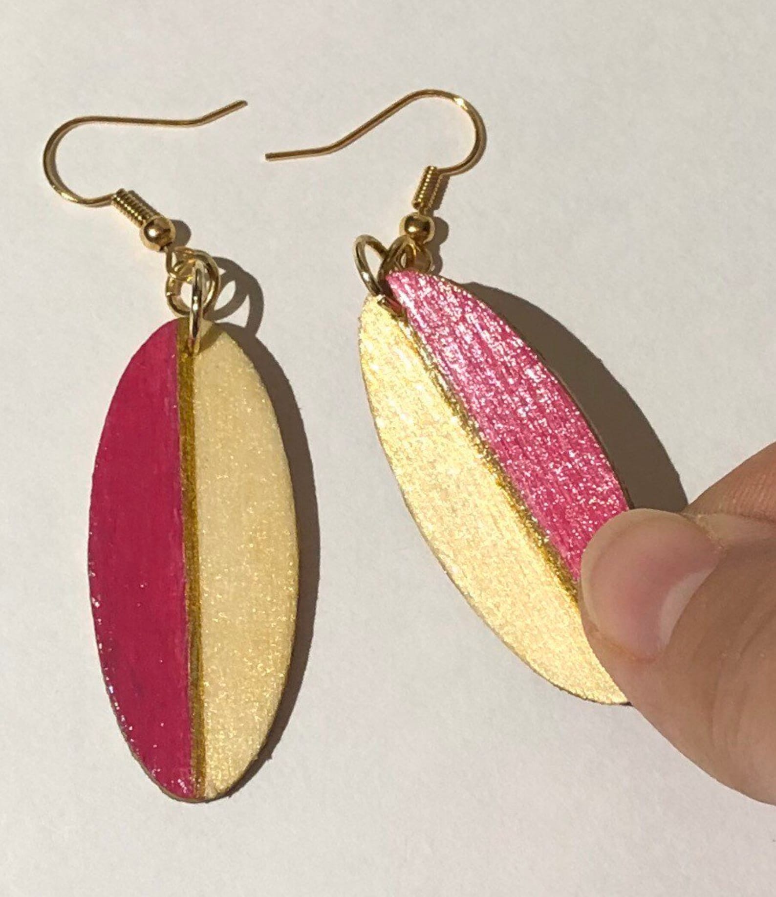 Pequeños pendientes de madera de forma oblonga pintados en hermosos ...