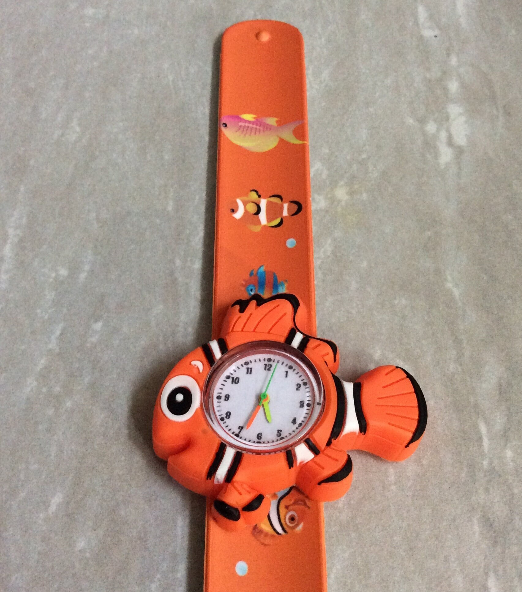 Orange Fish Watch Having a Round White Dial Black Numbered Hours on a ...