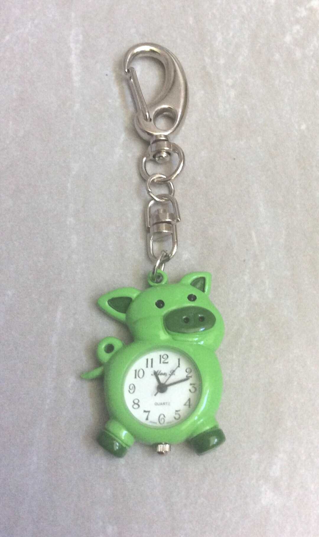 Lovely Green Pig Keychain Having a Round White Dial Black Arabic ...