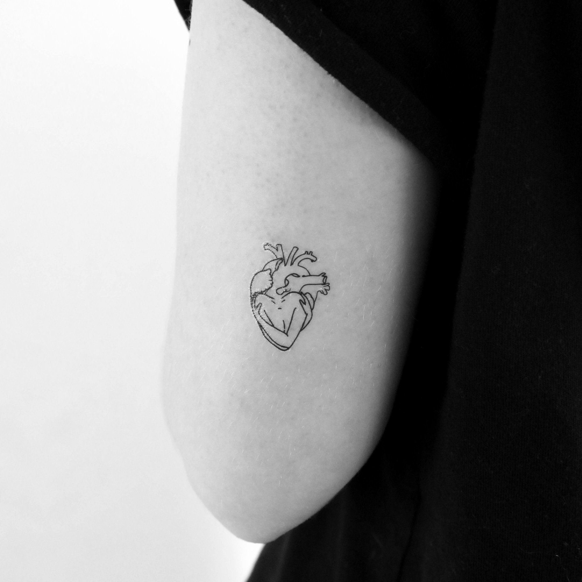 Hand Holding Human Heart Tattoo