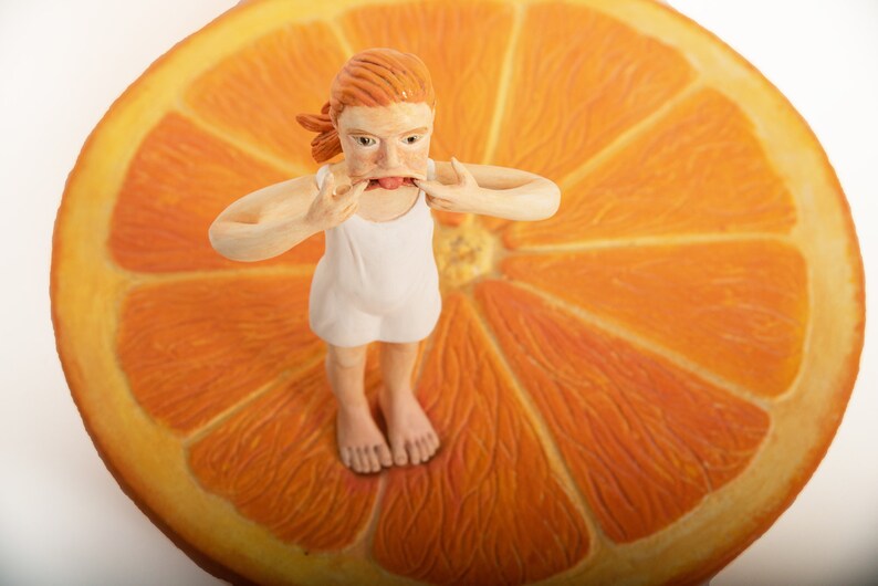 Scultura gigante in ceramica di una ragazza a forma di mezza arancia ...