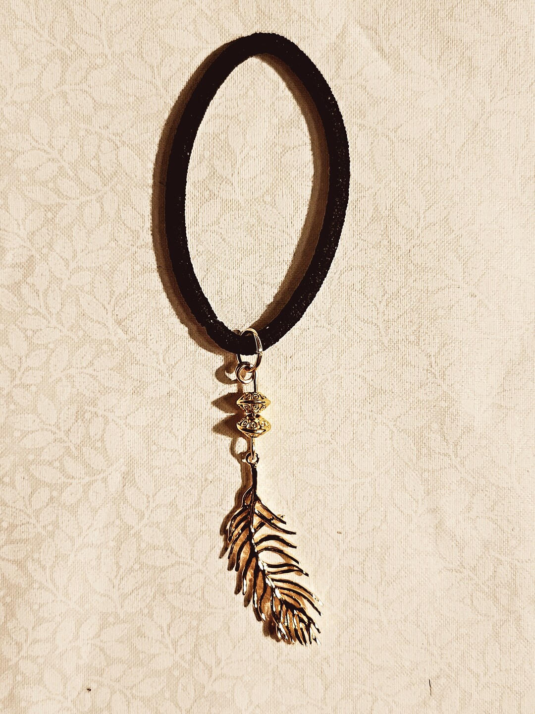 177 Delicate Golden Feather Dangles From a Black Scunci Hair Band. Two ...