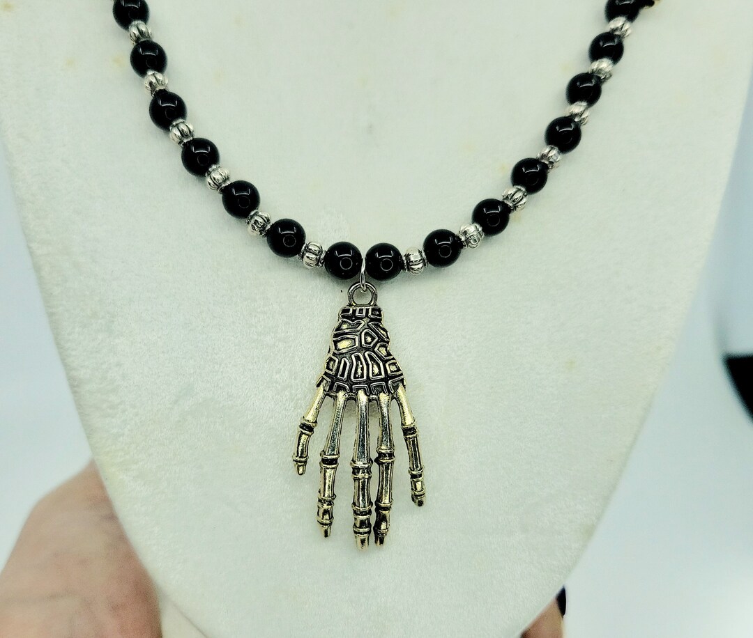 HALLOWEEN - Silver Skeleton Hand Pendant Hangs From a Black Agate ...