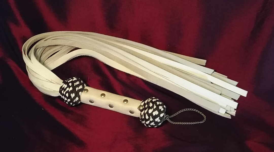 Flogger en cuero blanco con detalle de mango tejido blanco y negro ...