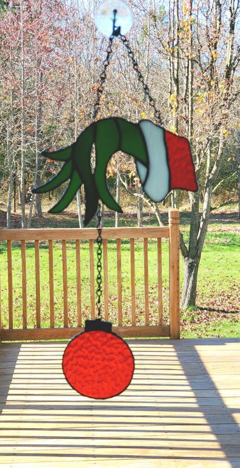 The Grinch holding a ball ornament stained glass suncatcher | Etsy