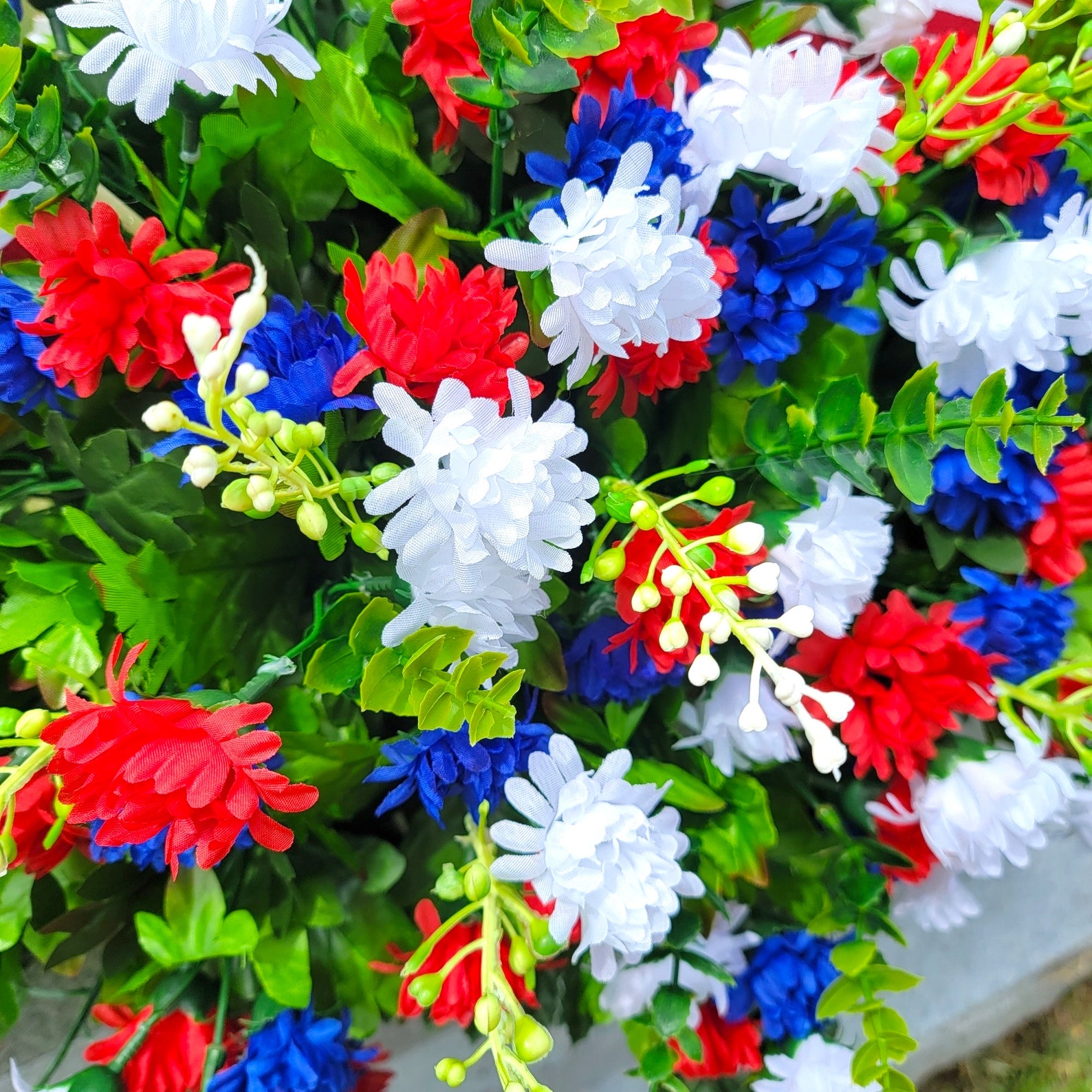 This Headstone Saddle Has Grave Flowers Including Red, White, & Blue ...