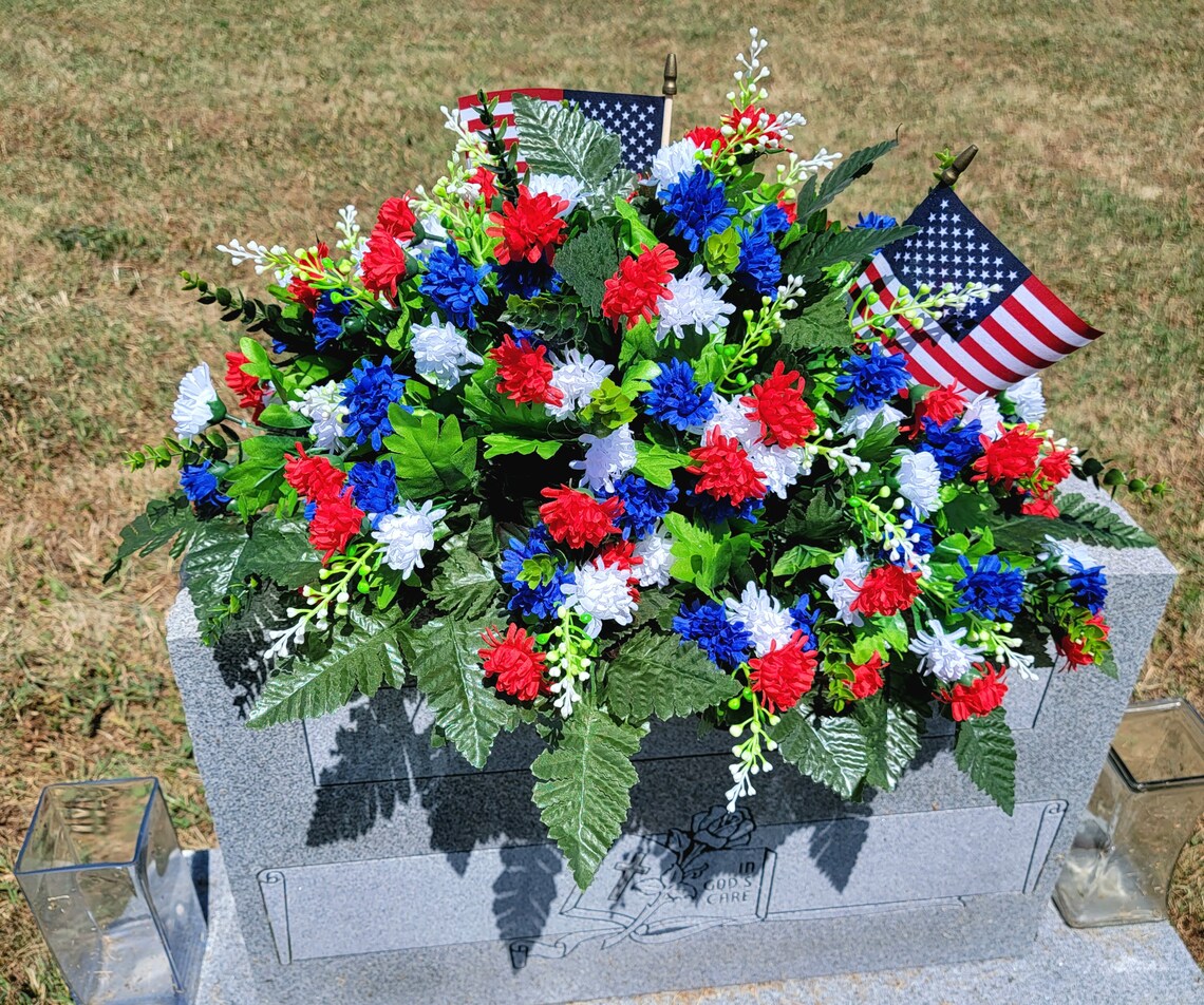This Headstone Saddle Has Grave Flowers Including Red, White, & Blue ...